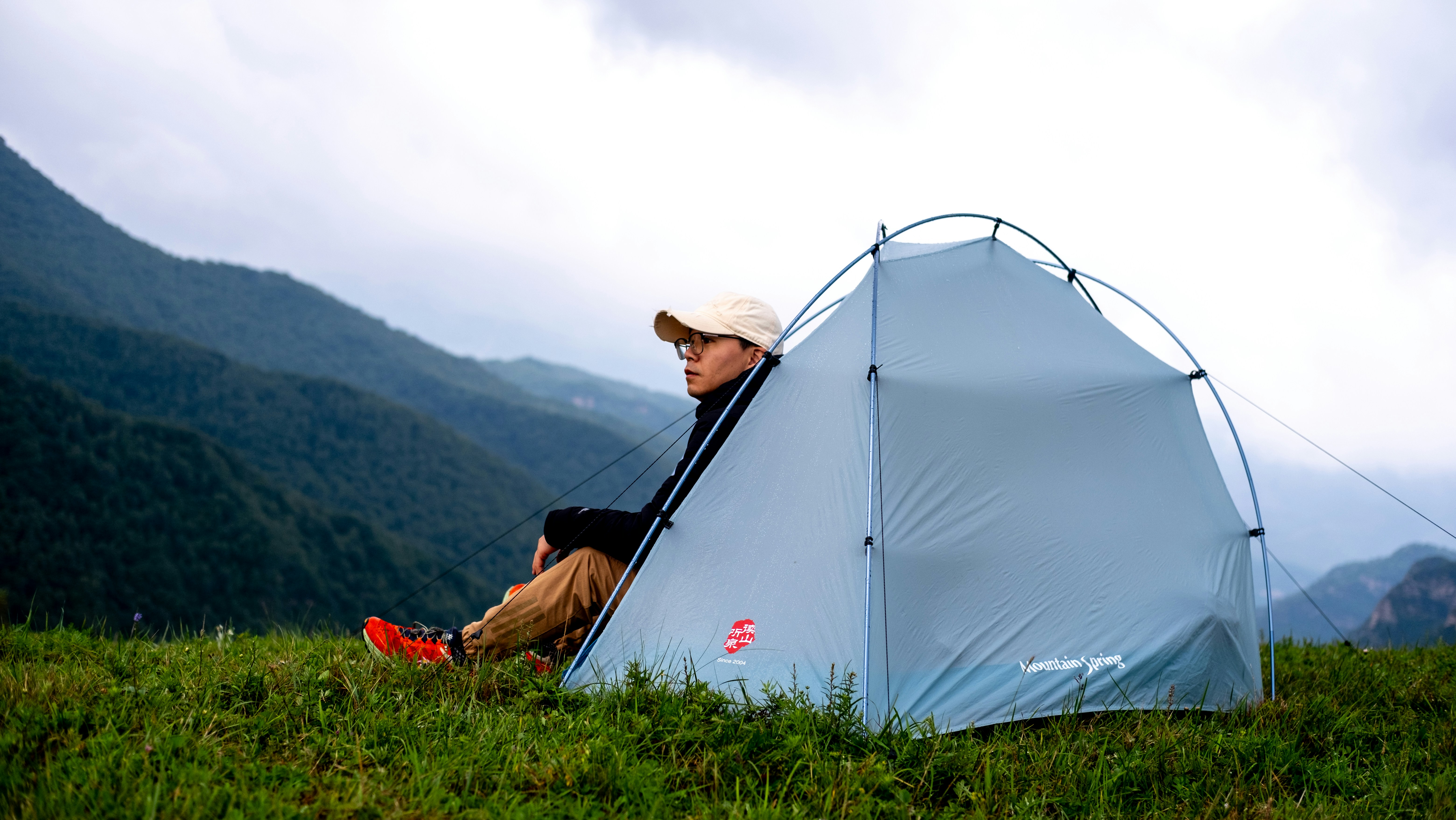 A person sits inside a tent, mountain view. photo – Free Human Image on ...
