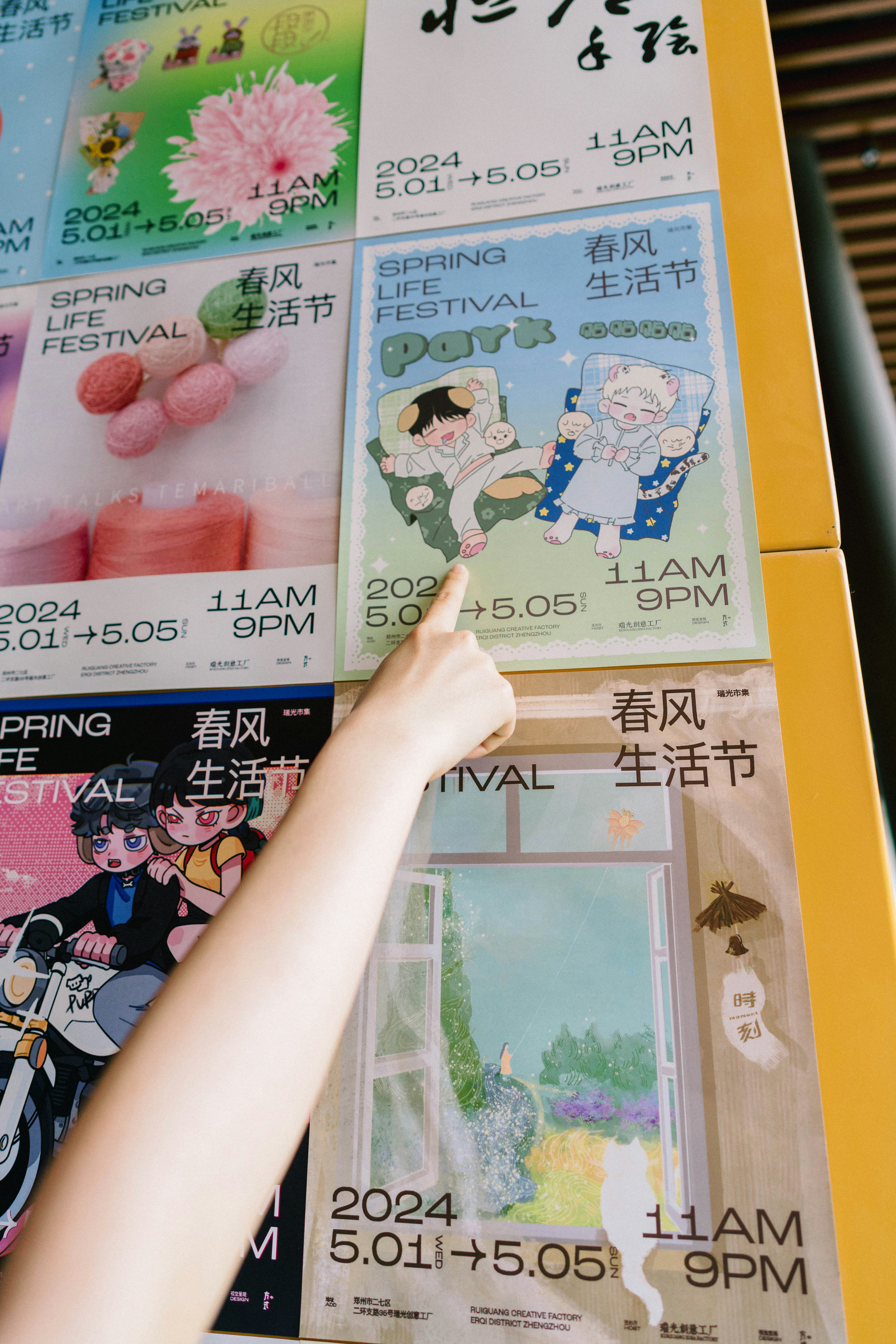 A hand points at posters advertising a spring festival. photo – Free ...