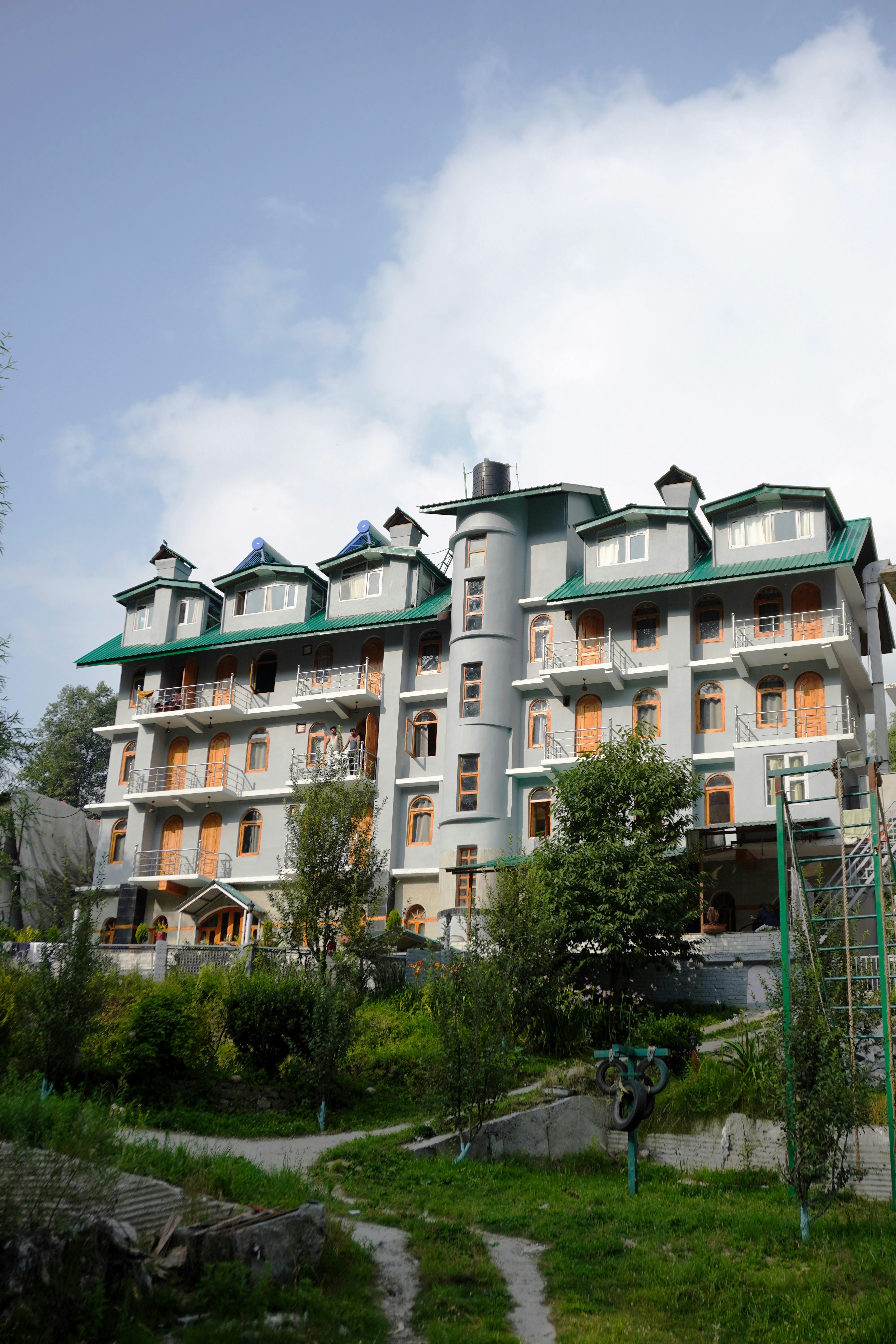Facade of a Sloped Alpine-Style Residential Building with Green Roofs