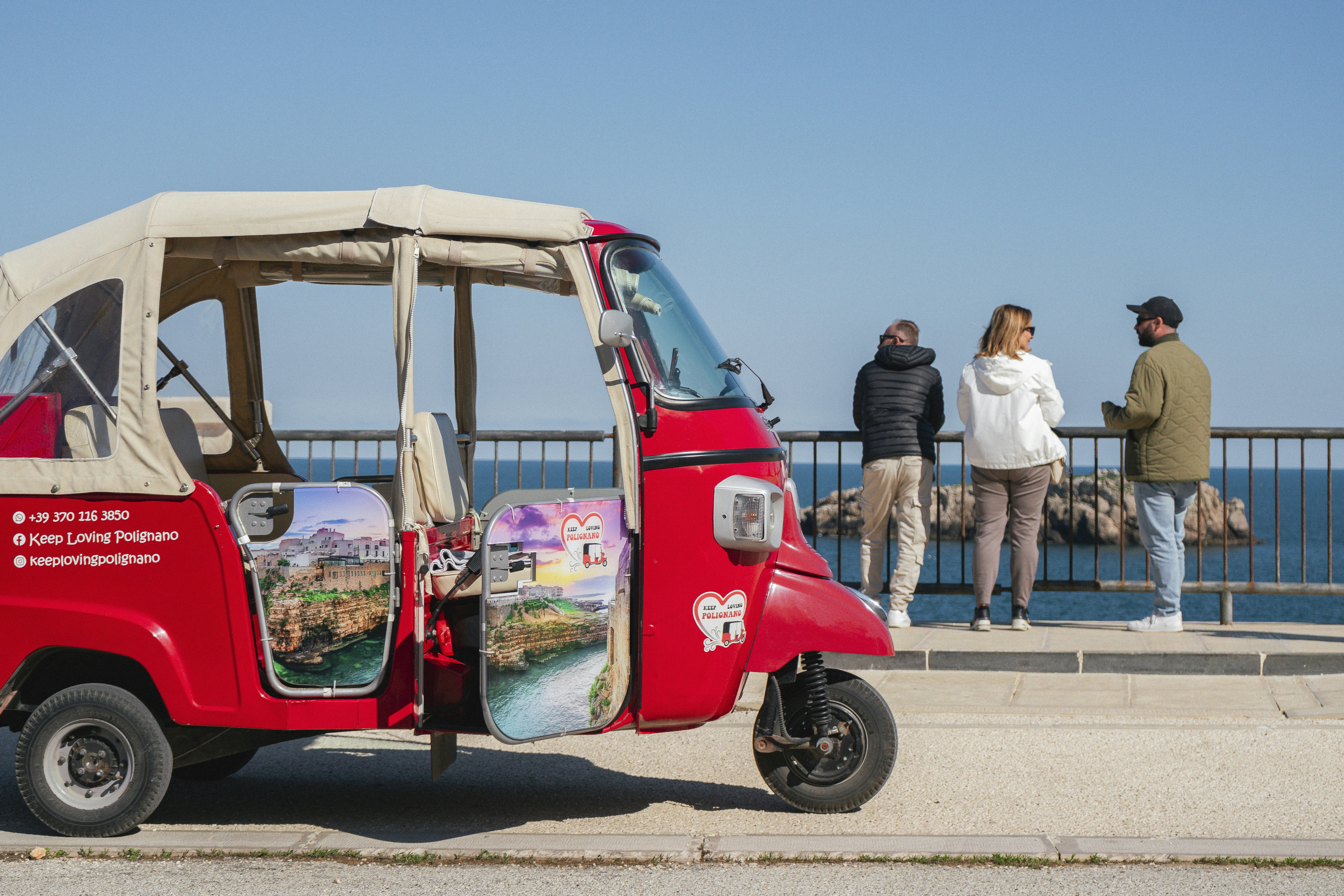 Crimson Tuk-Tuk at the Seafront: Quiet Pause by the Rail