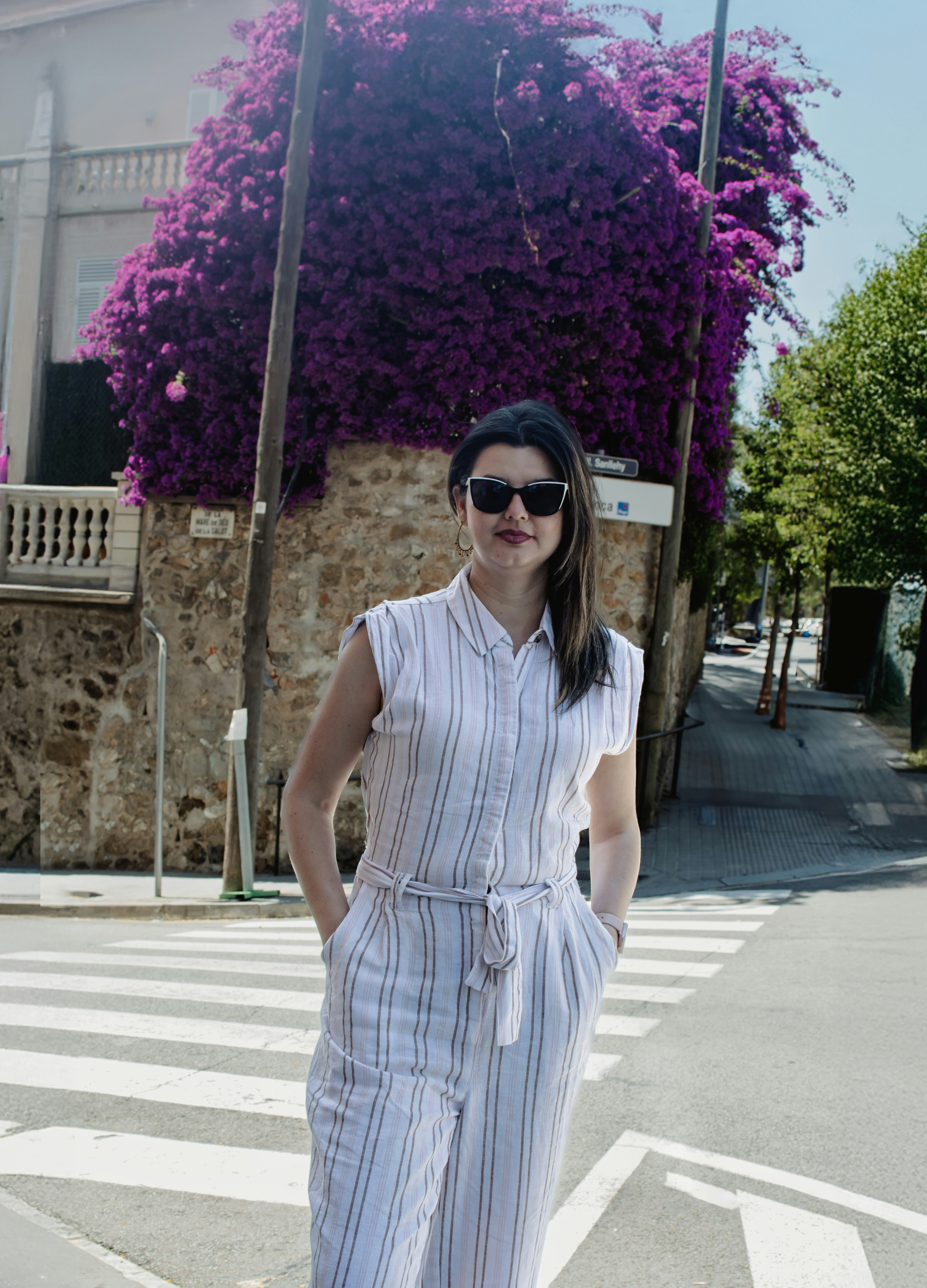 Femme pose sur un passage piéton avec un mur de fleurs en fleurs. photo ...