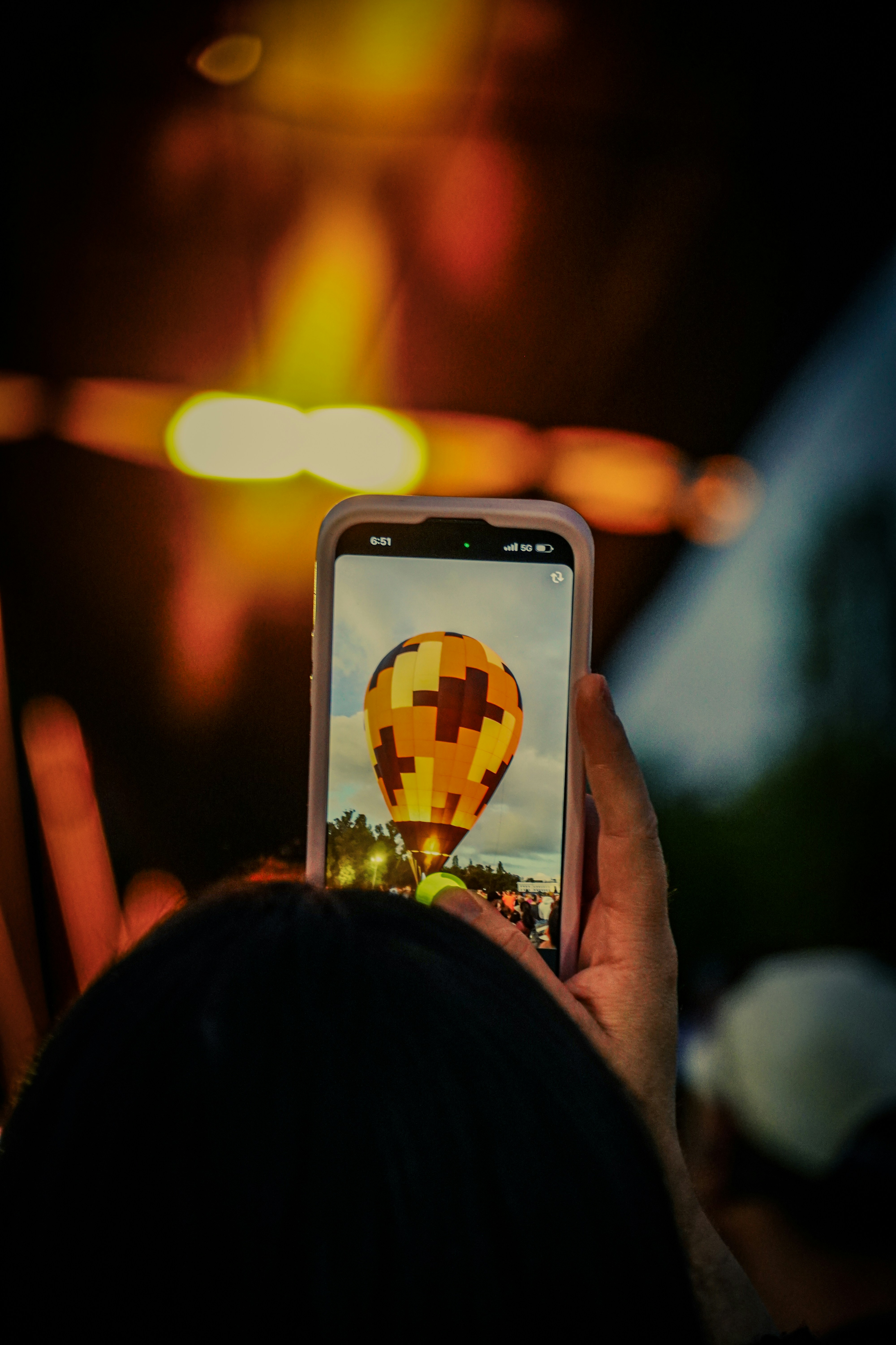 Capturing a Neon Night: A Handheld Moment Framing a Balloon on a Phone Screen