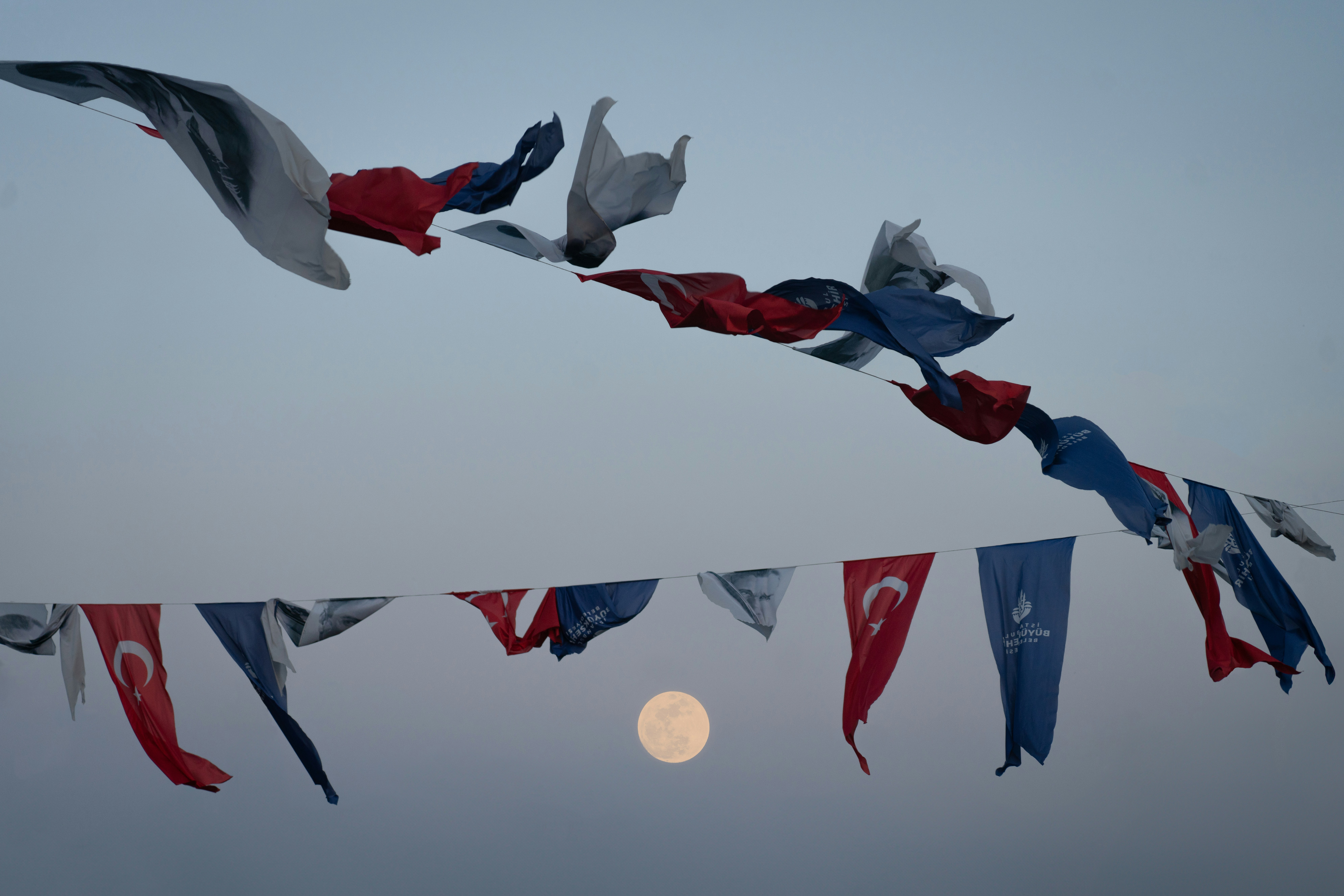 Flags fly above a full moon. photo – Free Wallpaper Image on Unsplash