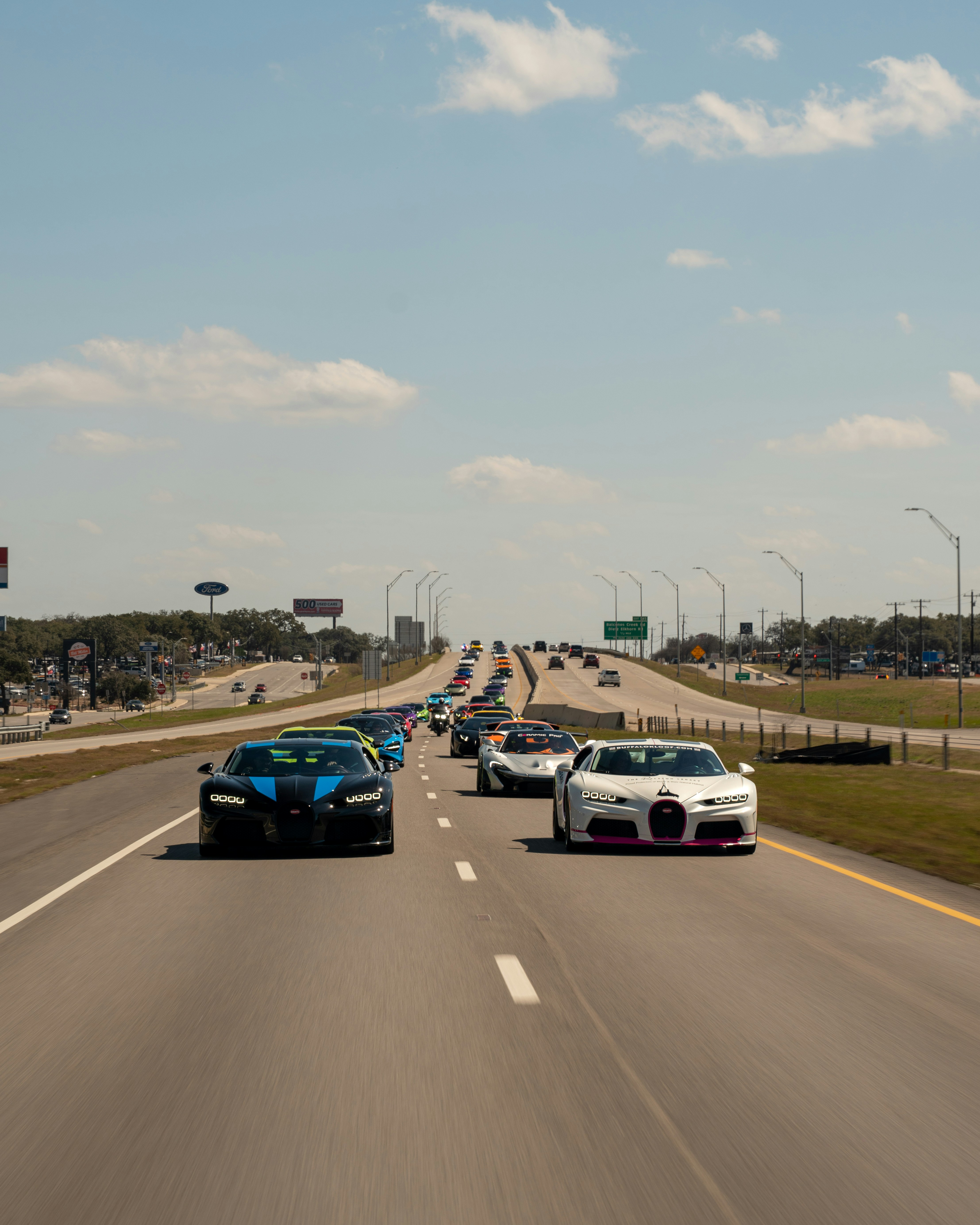 Many bugatti supercars are driving down the highway. photo – Free ...