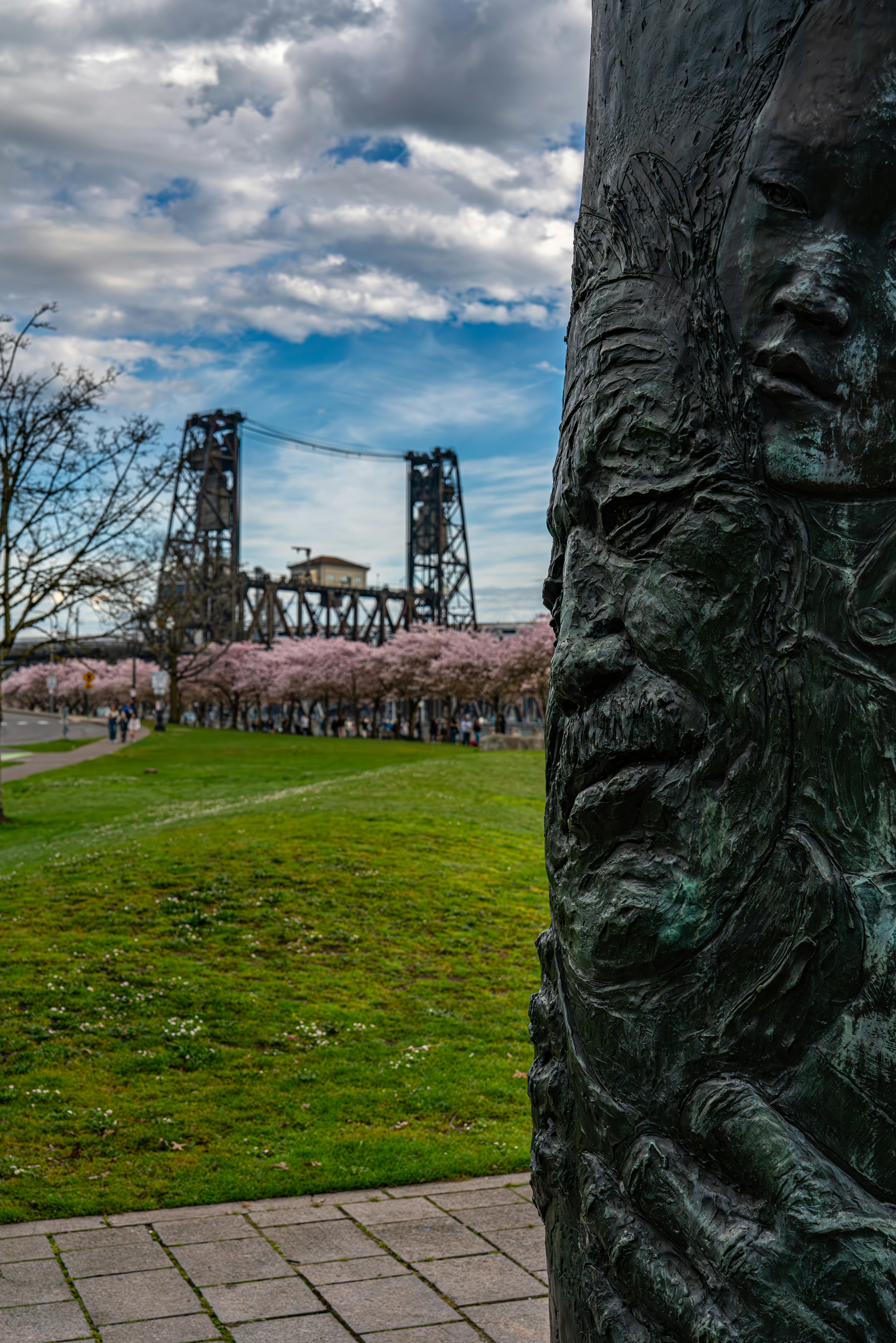 Textured Sentinel by the Blossoms: A Park Scene with a Distant Bridge