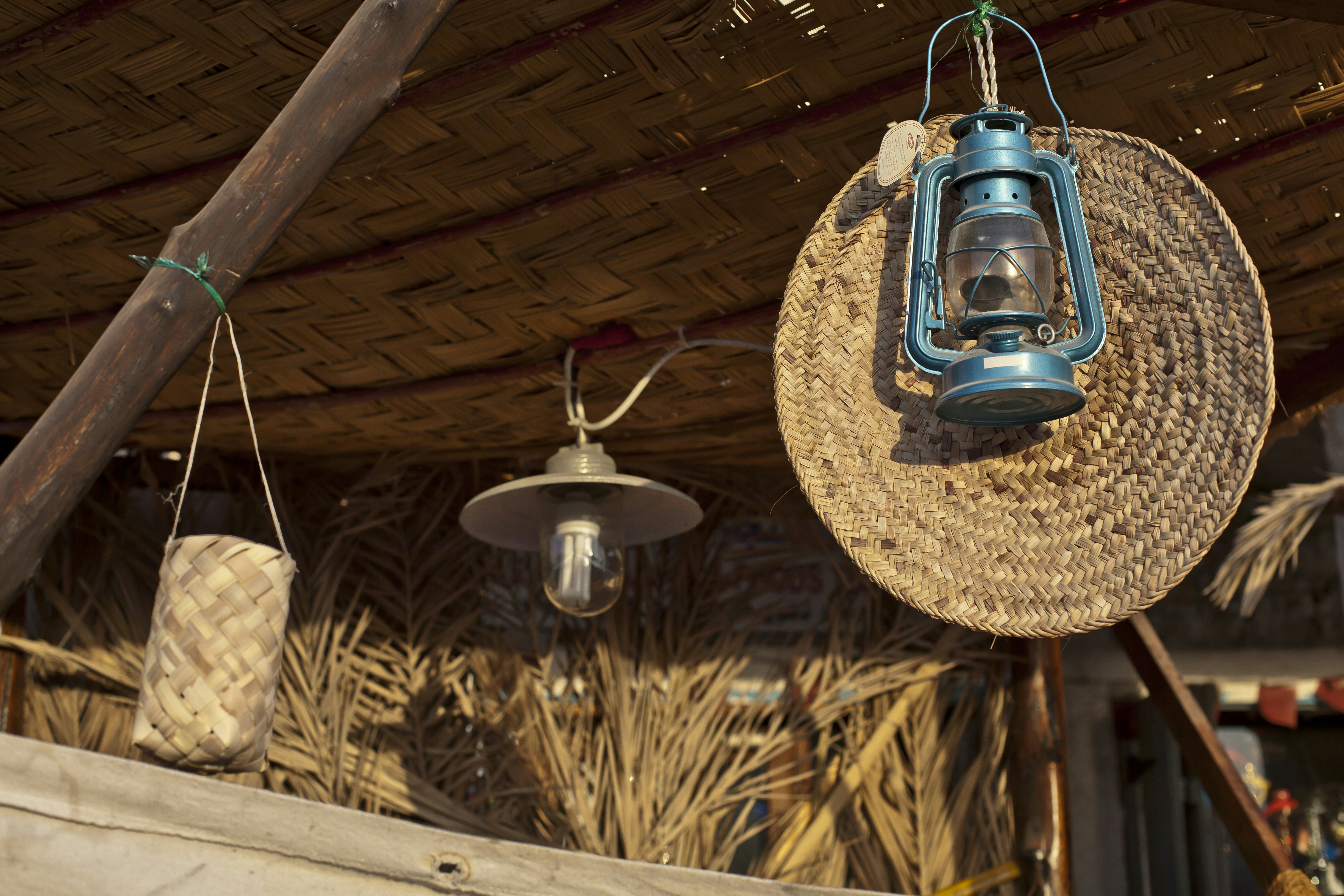 Lanterns and woven decor hang from a rustic ceiling.