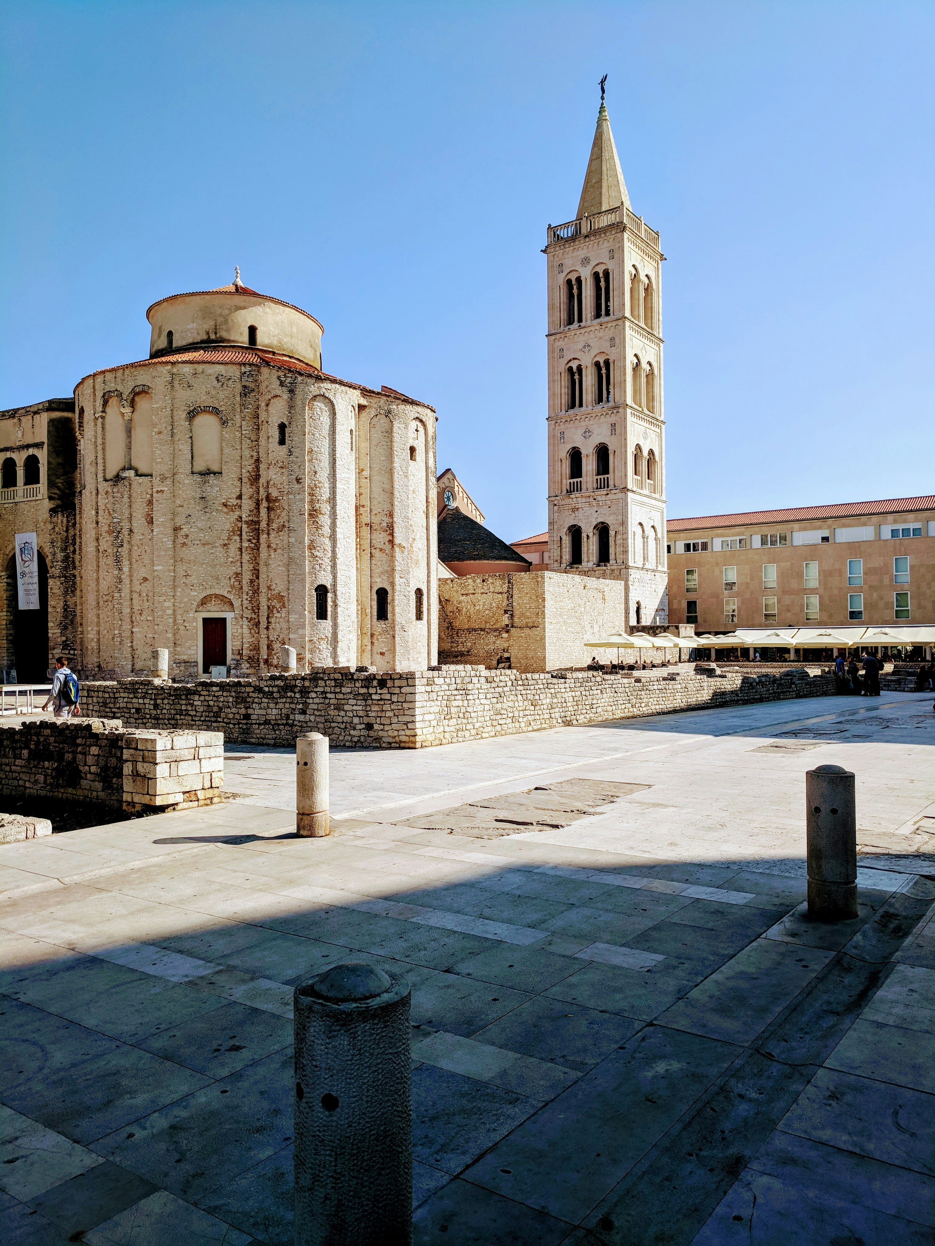 Sunlit Facades: A Historic Church and Bell Tower Soaring Over a Quiet Plaza