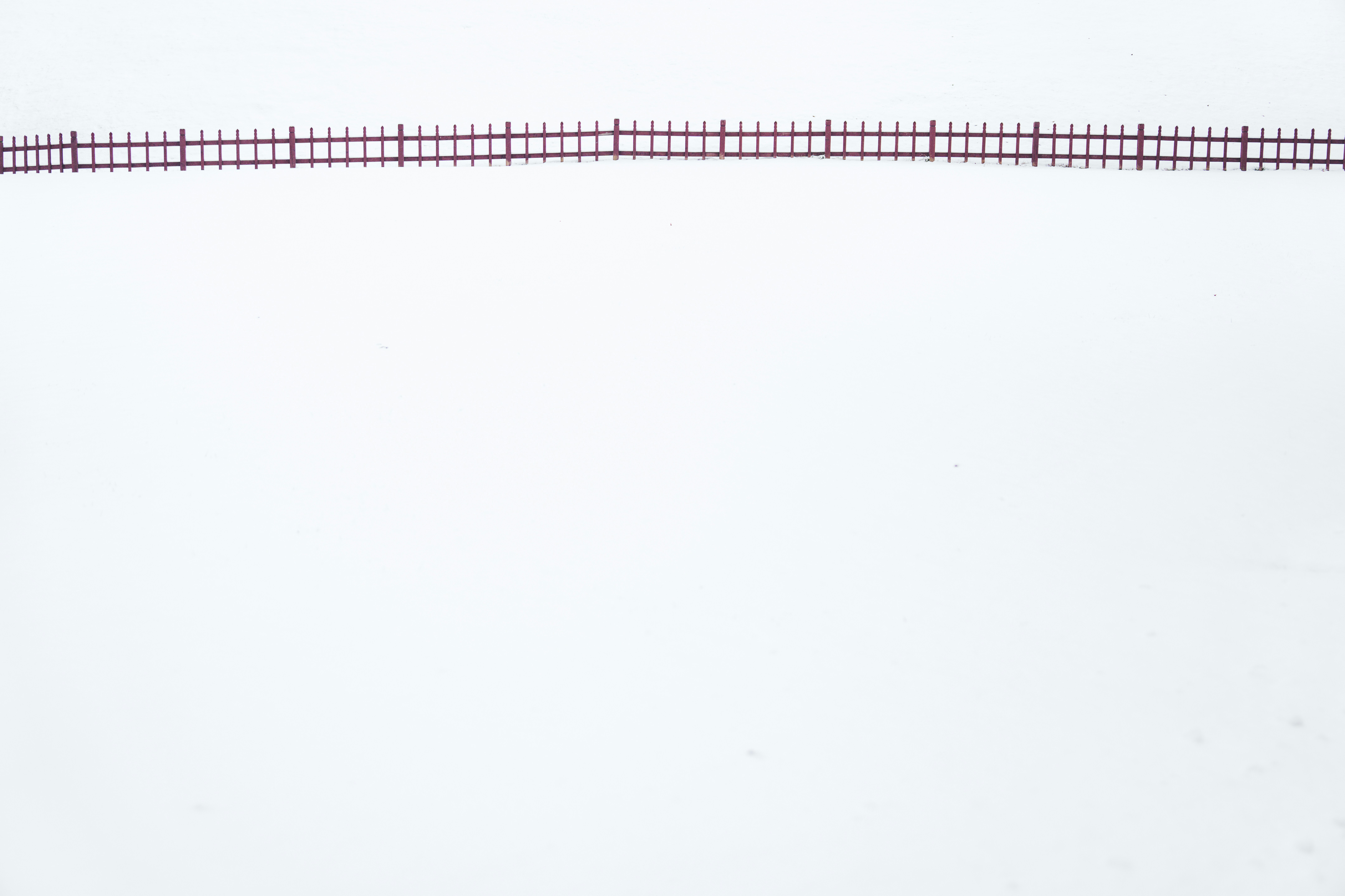 Line in White: A Thin Rail Traverses a Quiet Snowfield