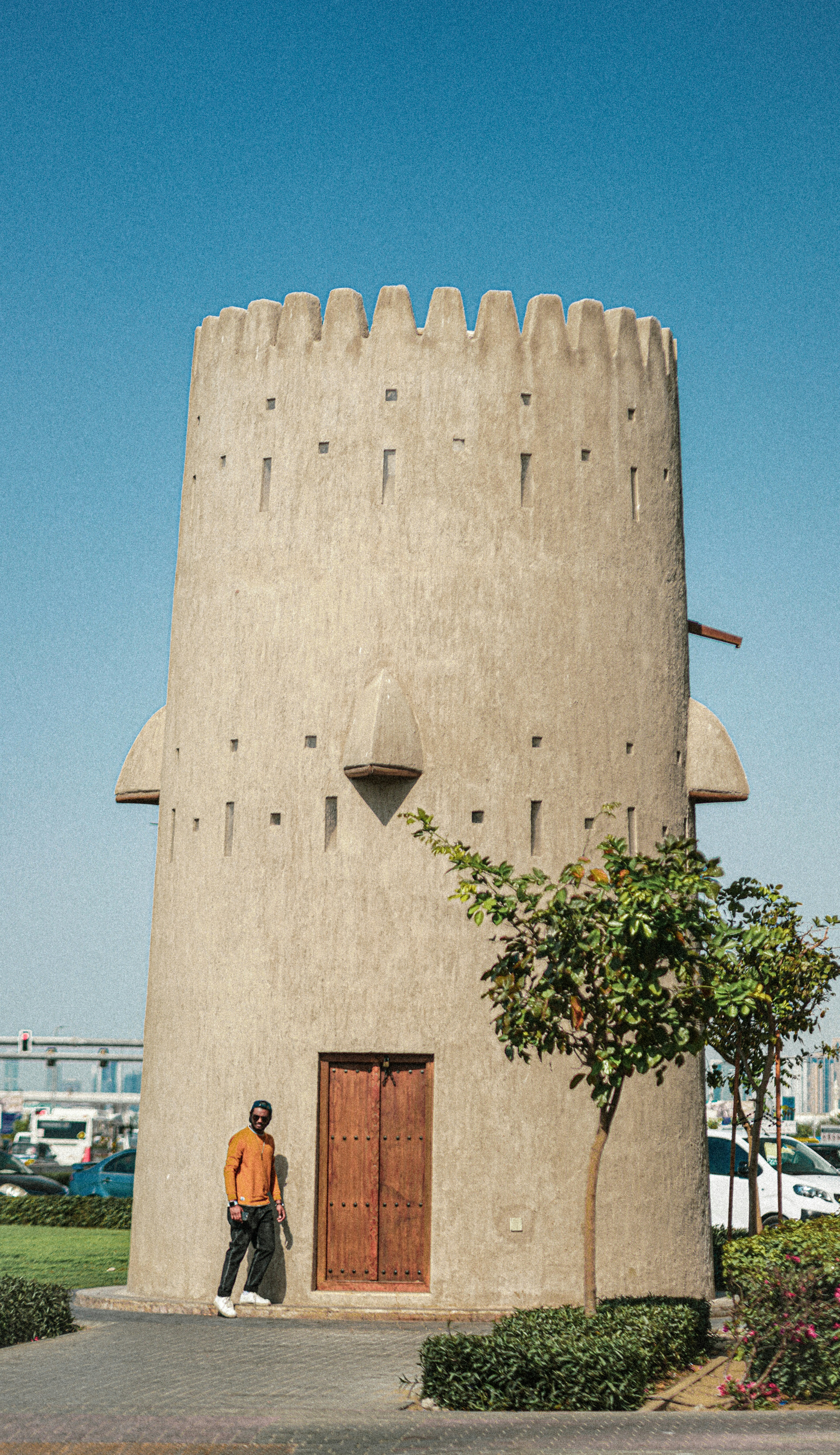 Orange-Clad Observer at a Sunlit Turreted Tower