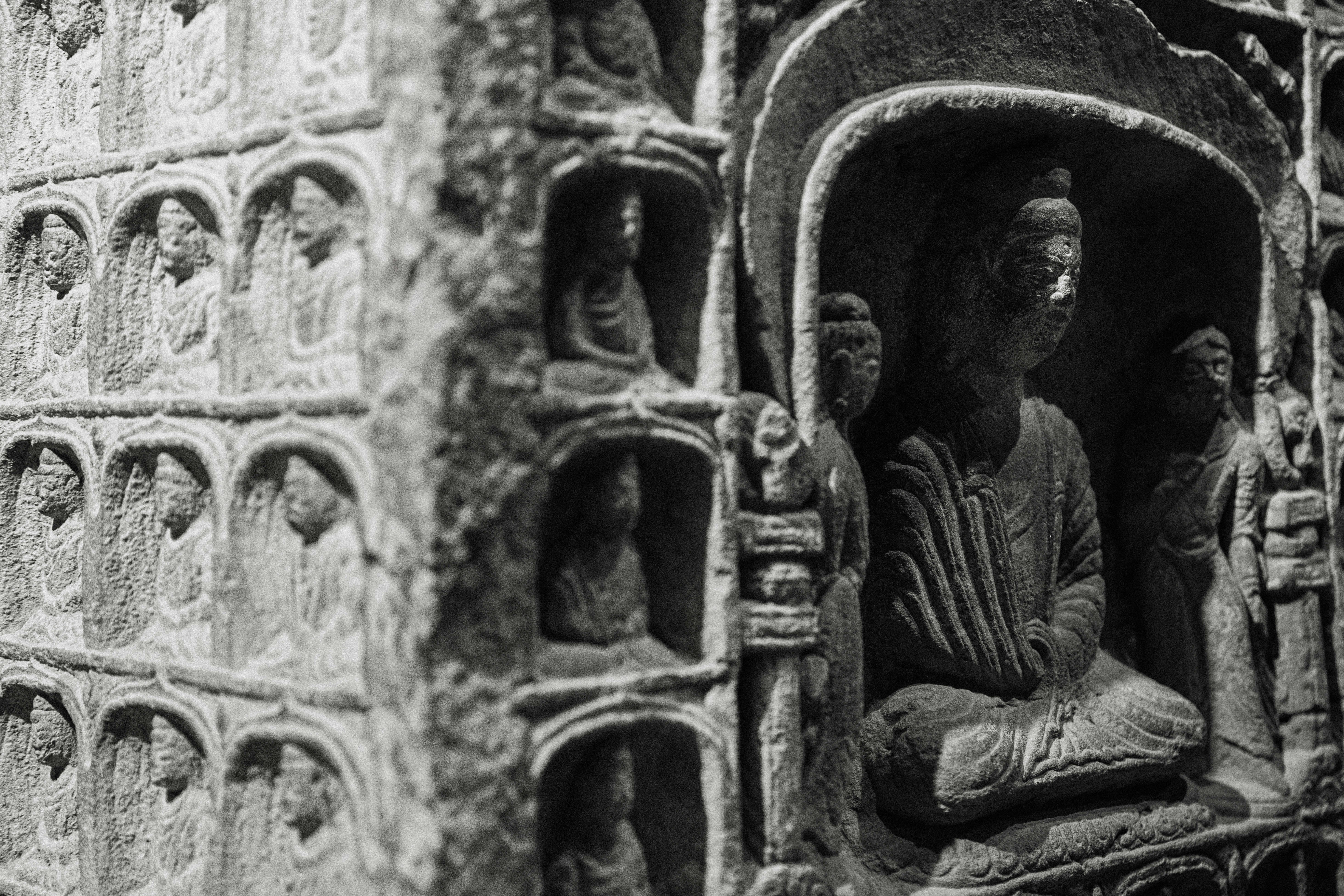Silent Watchers: A Stone Buddha Carved in Shadowed Niche