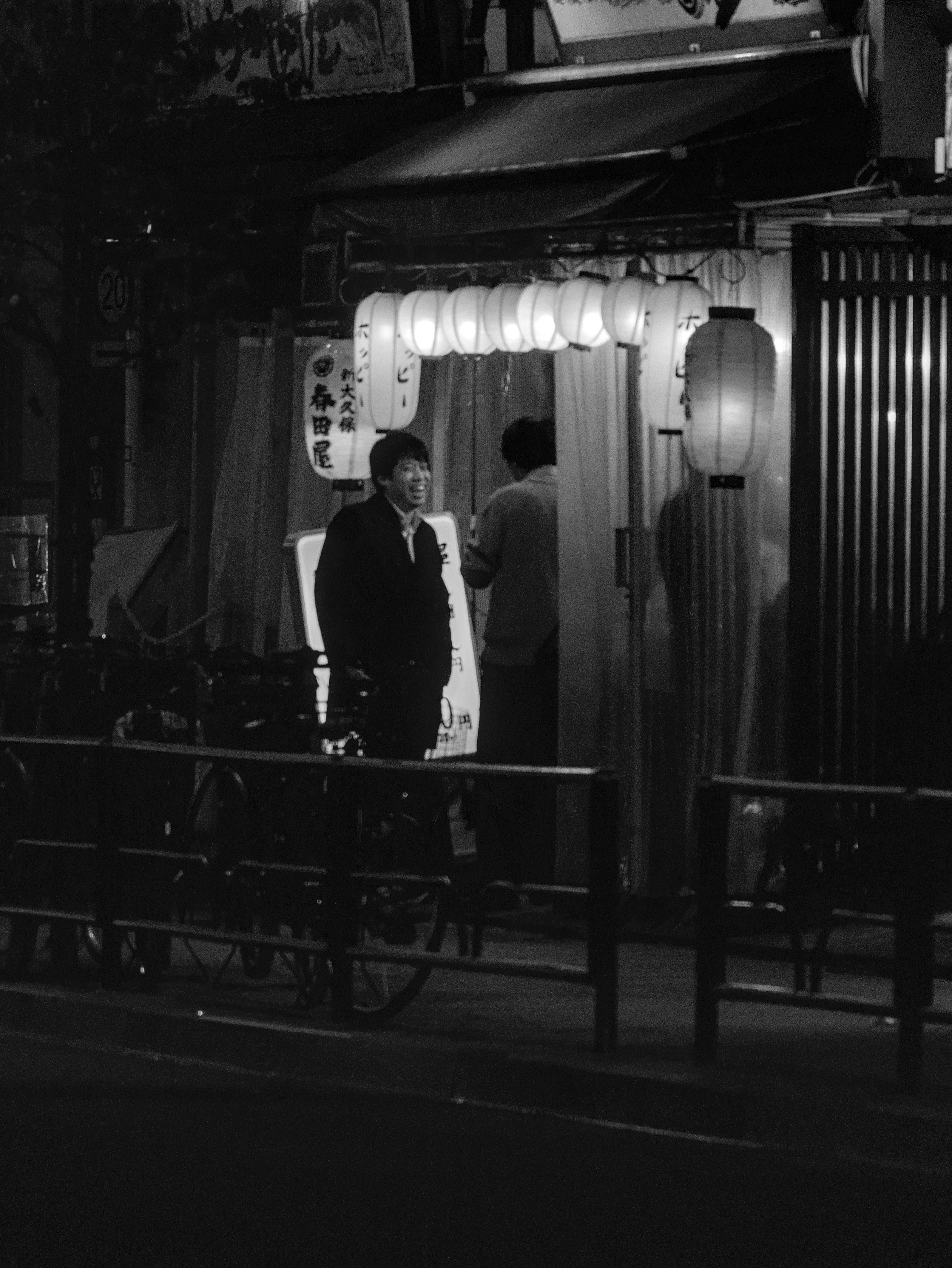 People stand outside a dimly lit restaurant at night. photo – Free ...