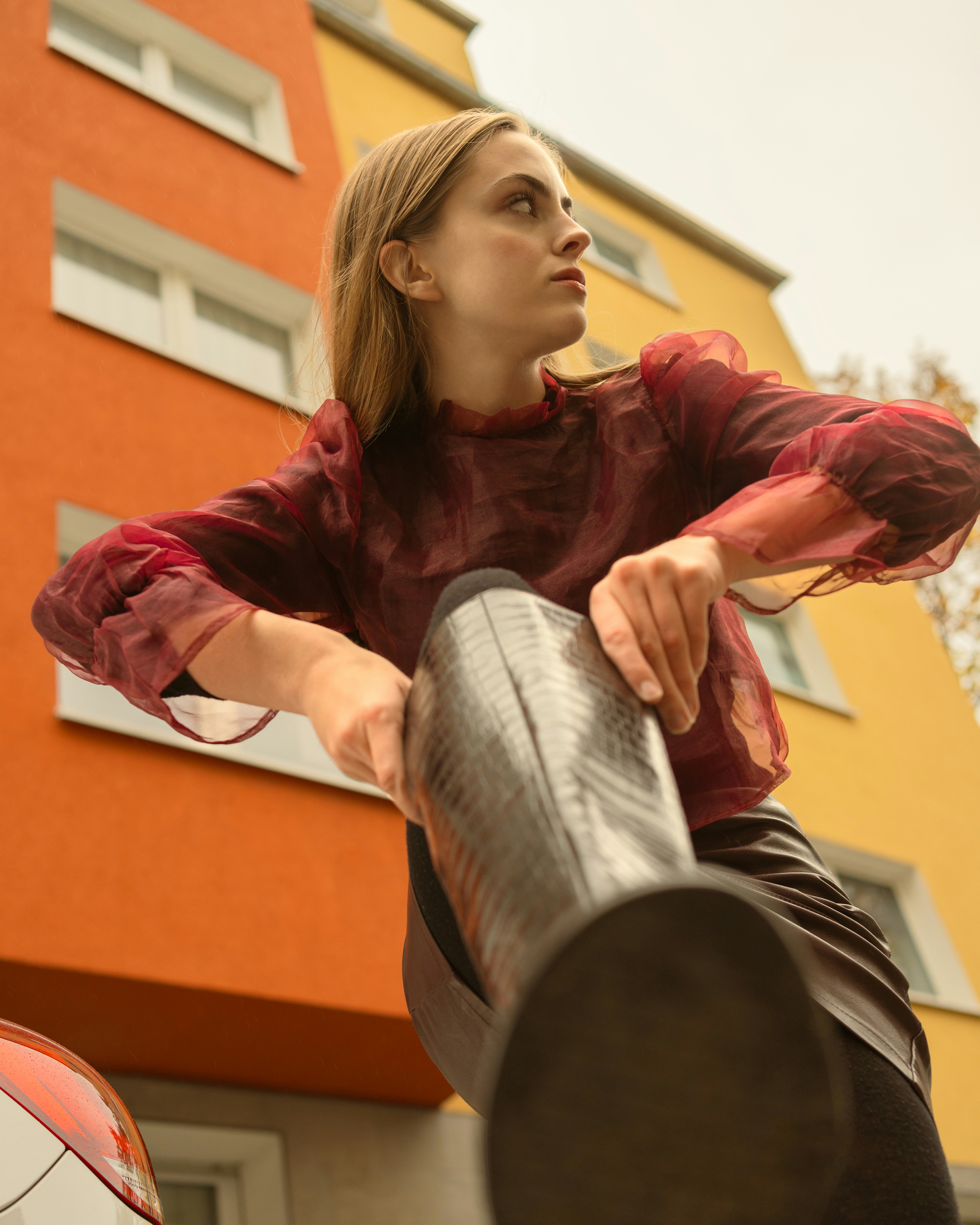 A woman poses next to colorful apartment buildings. photo – Free ...