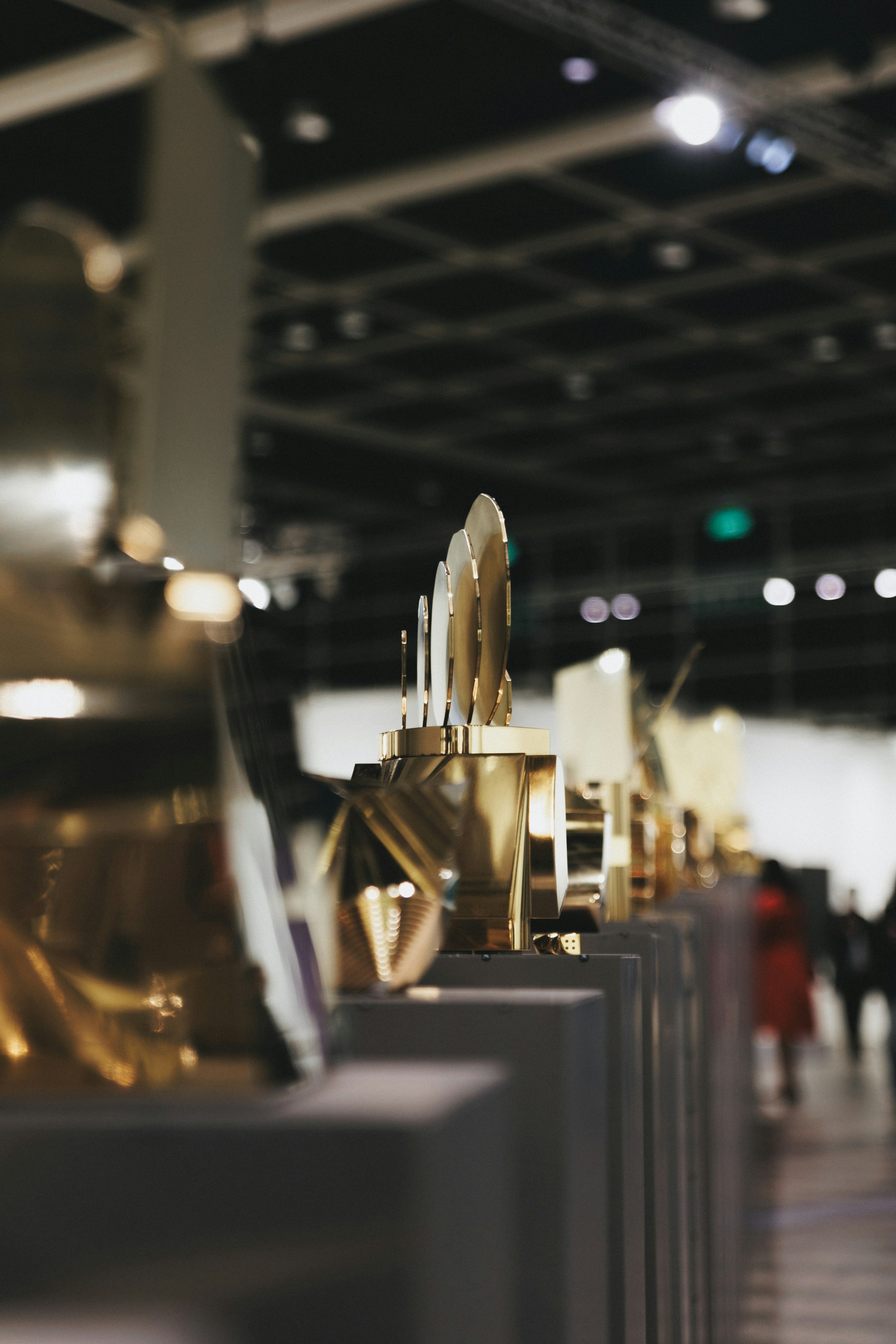 Gilded sculpture lineup glints along a museum-like display