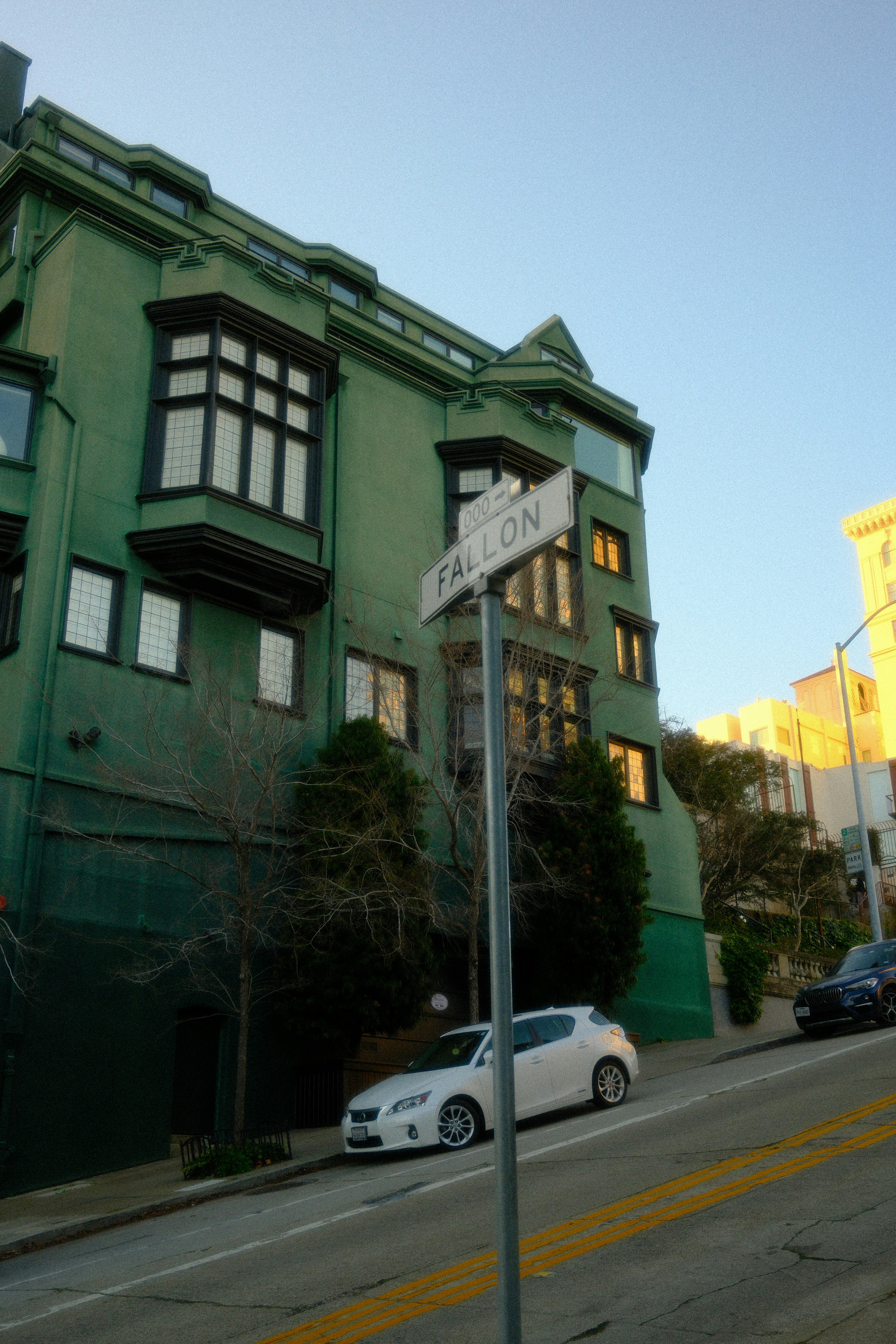 Un edificio verde con un letrero en la calle. foto – Imagen de Coche ...