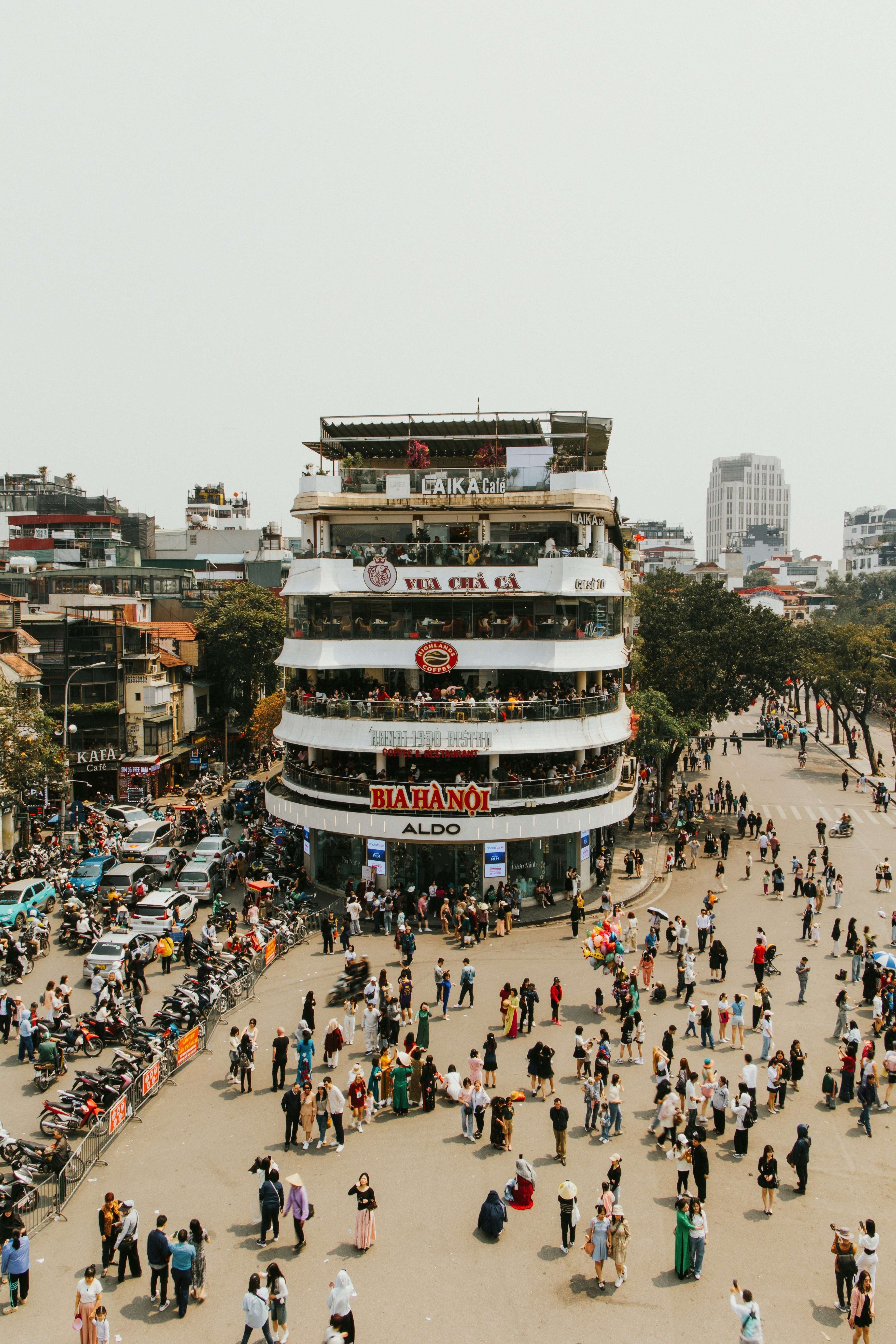 Multi-story Circular Café Tower Amid a Sea of Pedestrians