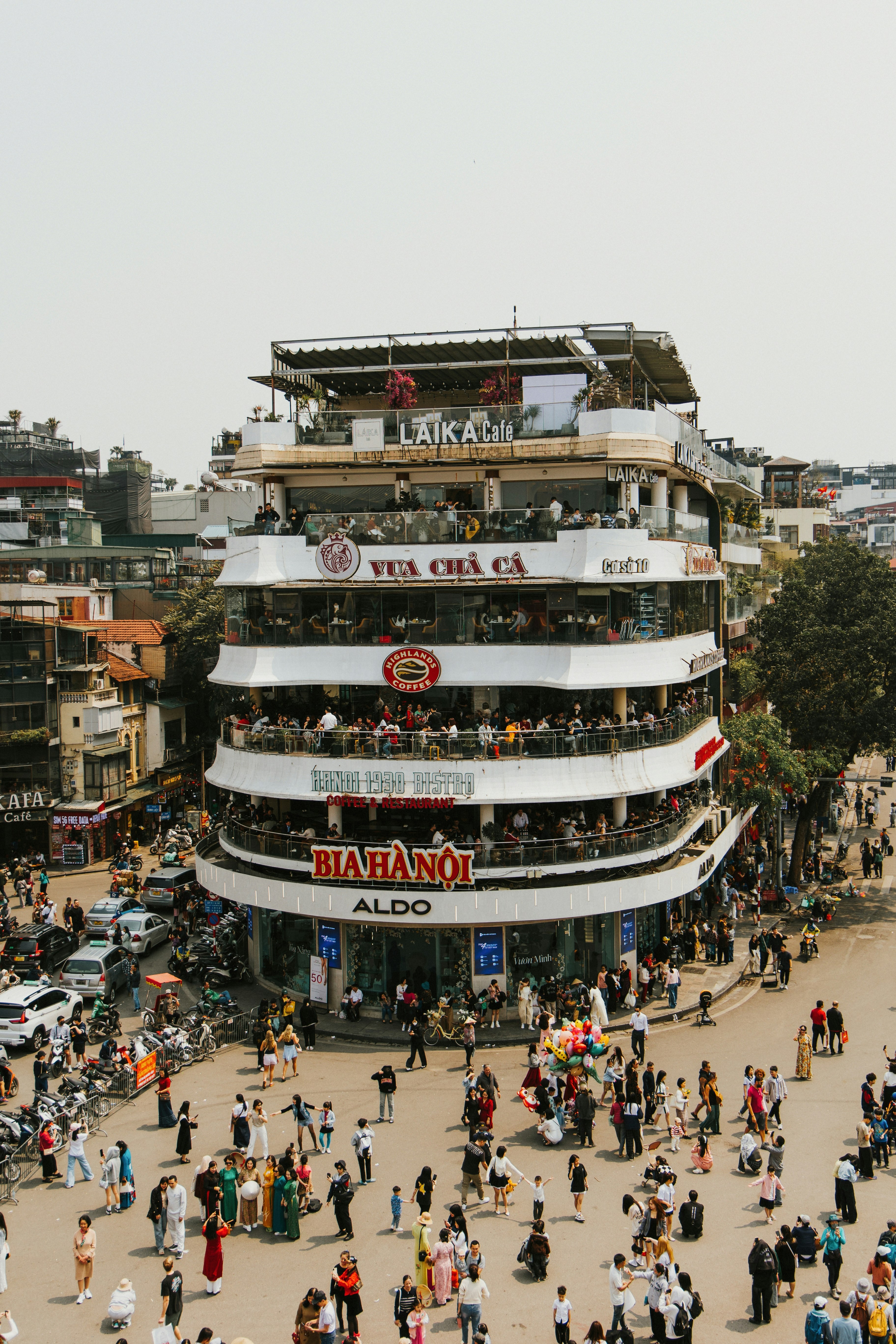 Spiral Café Tower: Hanoi's Multi-Level Beacon Amid a Bustling Street Scene