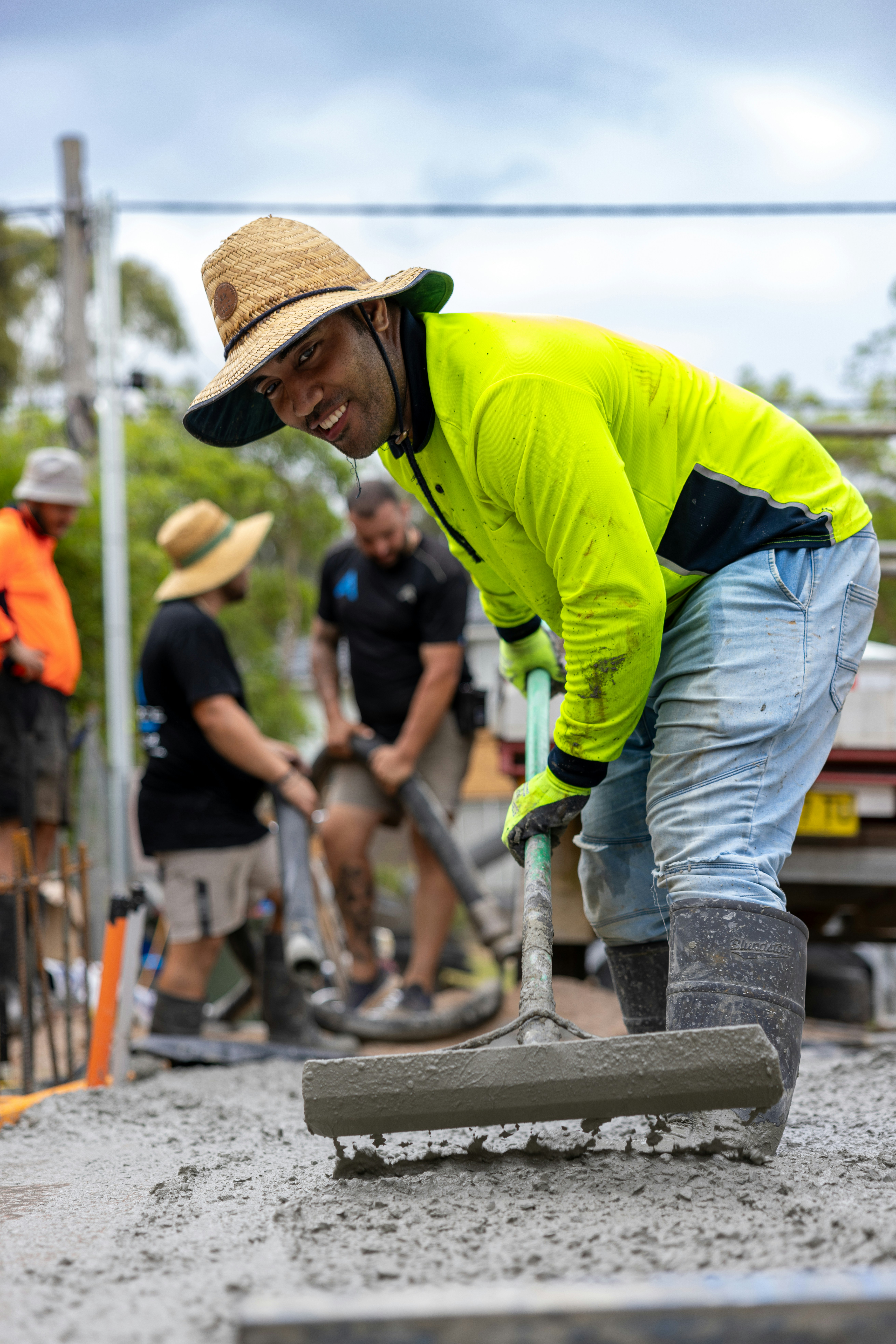 Worker leveling concrete with a rake on a construction site. photo ...