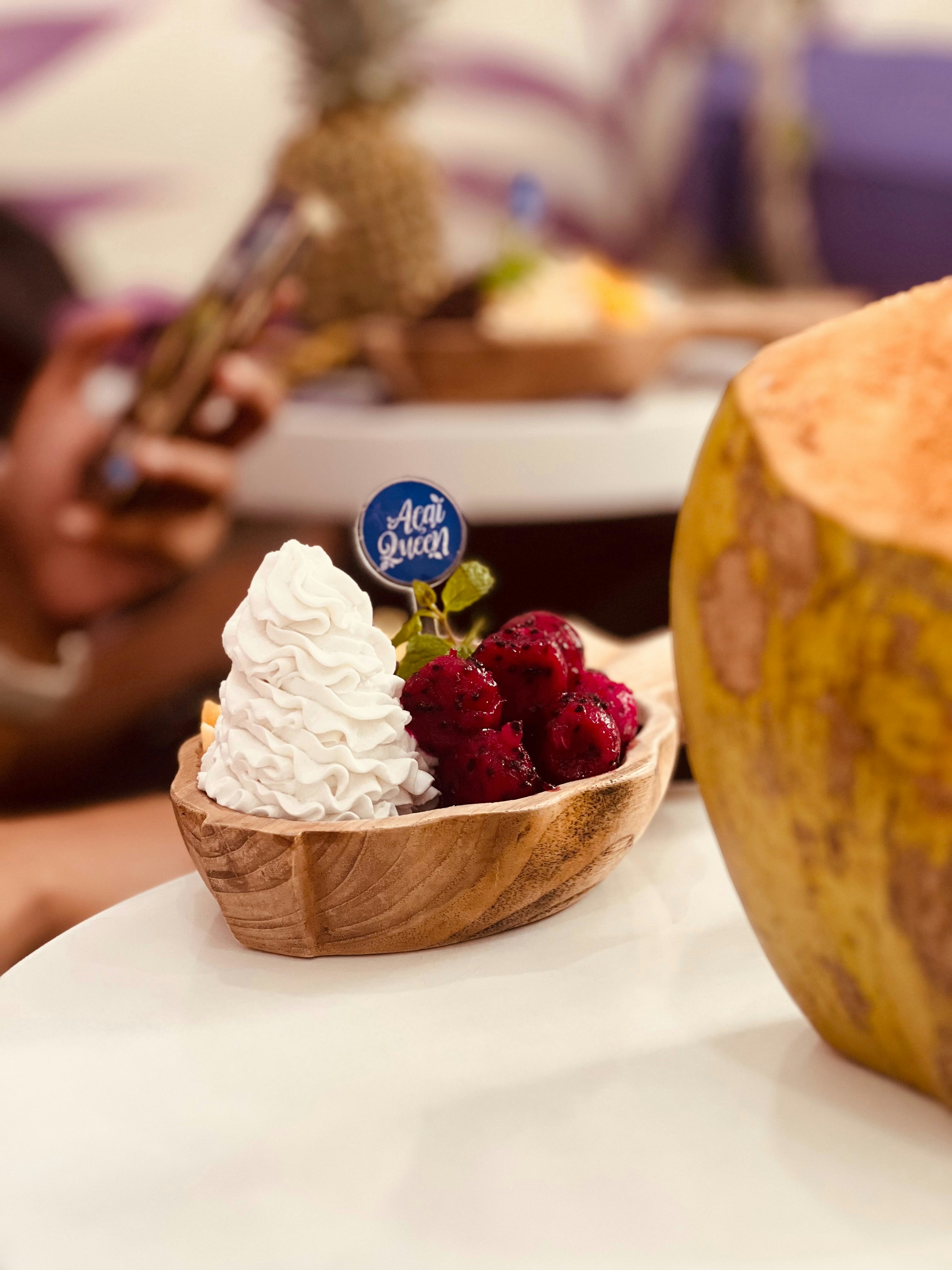 Whipped Peaks and Ruby Berries in a Wooden Bowl under Soft Indoor Glow