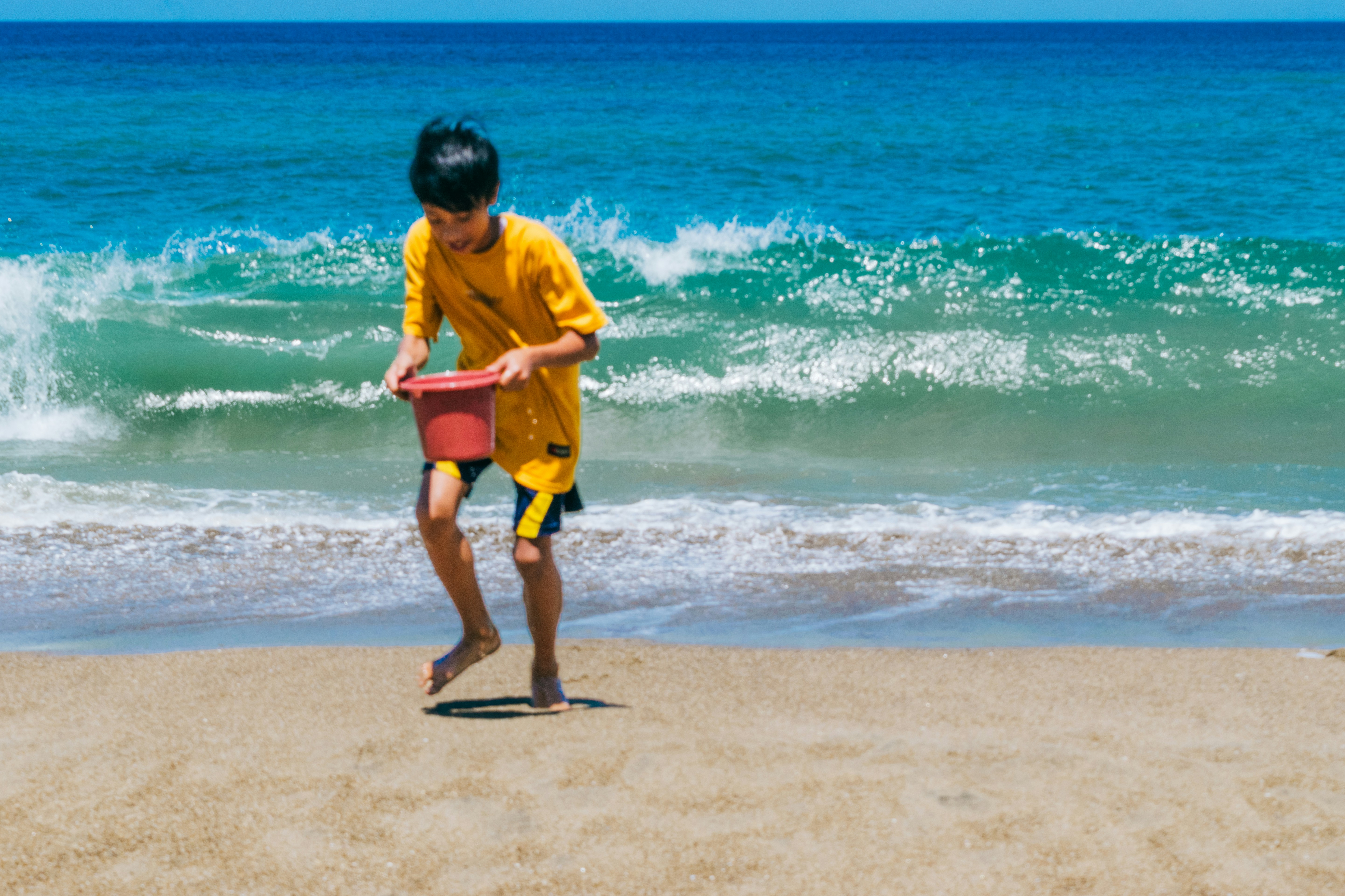 Beach Sprint: A Yellow-Shirted Dash with a Pink Bucket