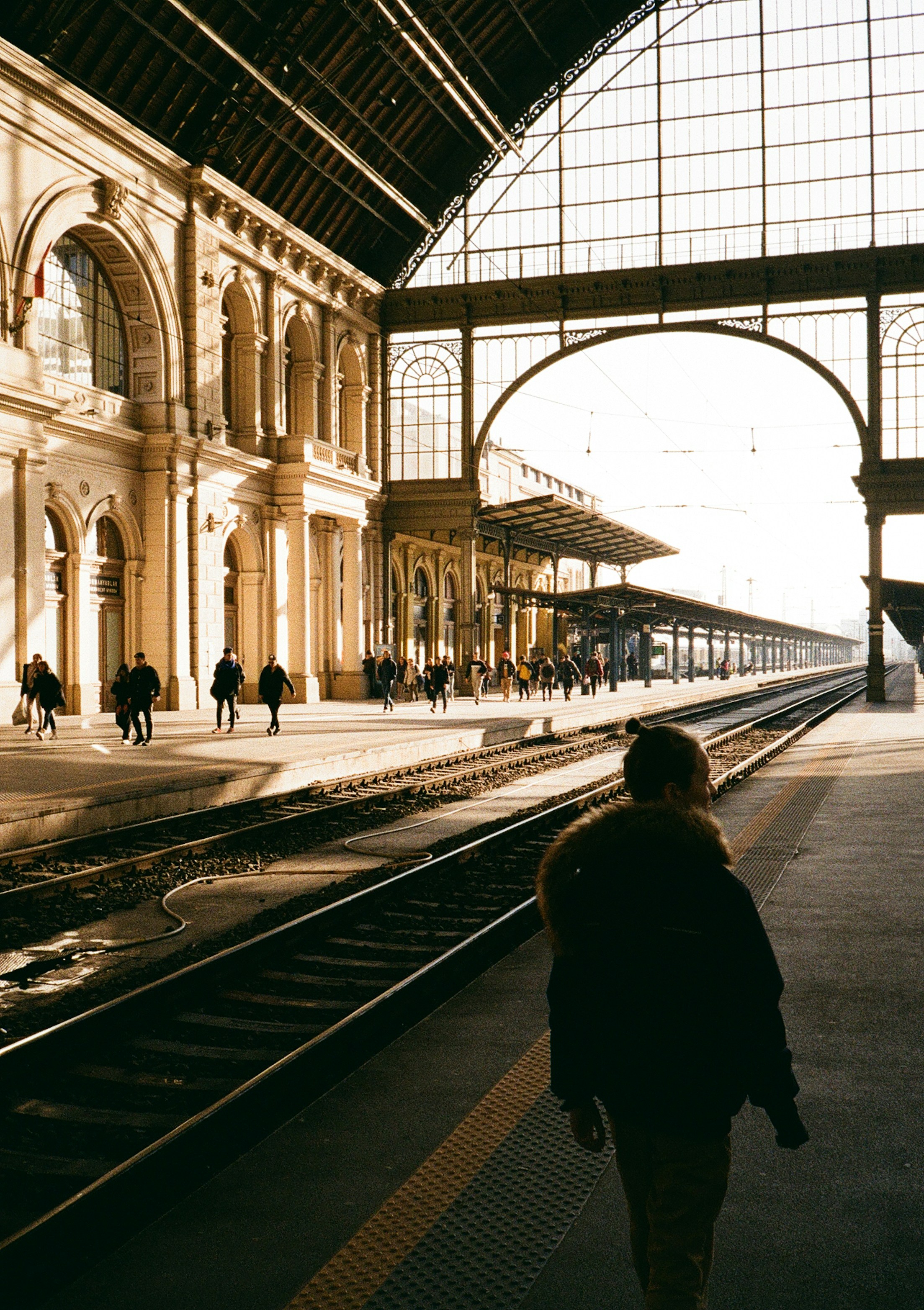 La personne marche le long d’un quai de train vers la lumière du soleil ...