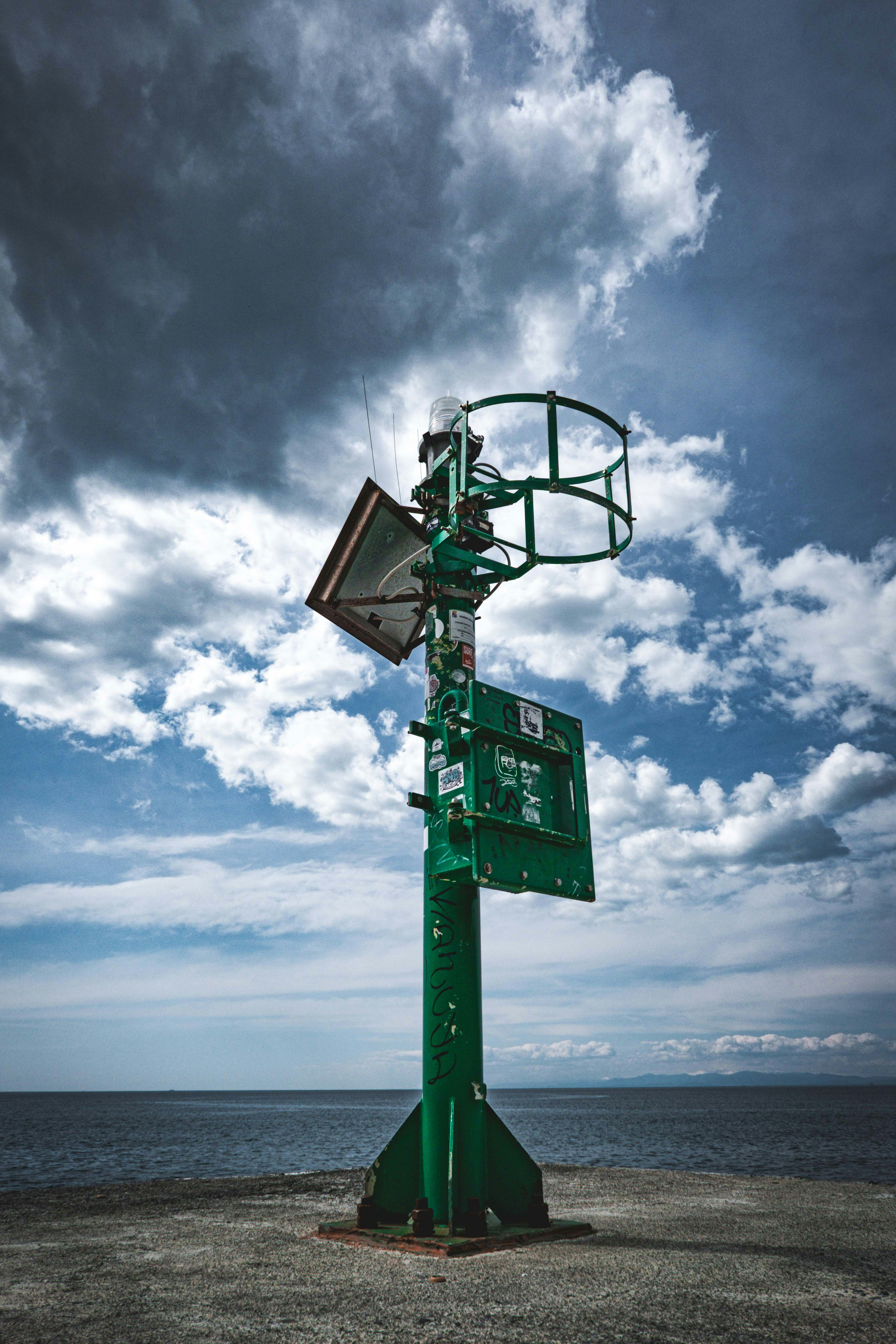 Verdant Sentinel by the Sea: A Coastal Beacon in Weathered Green Steel