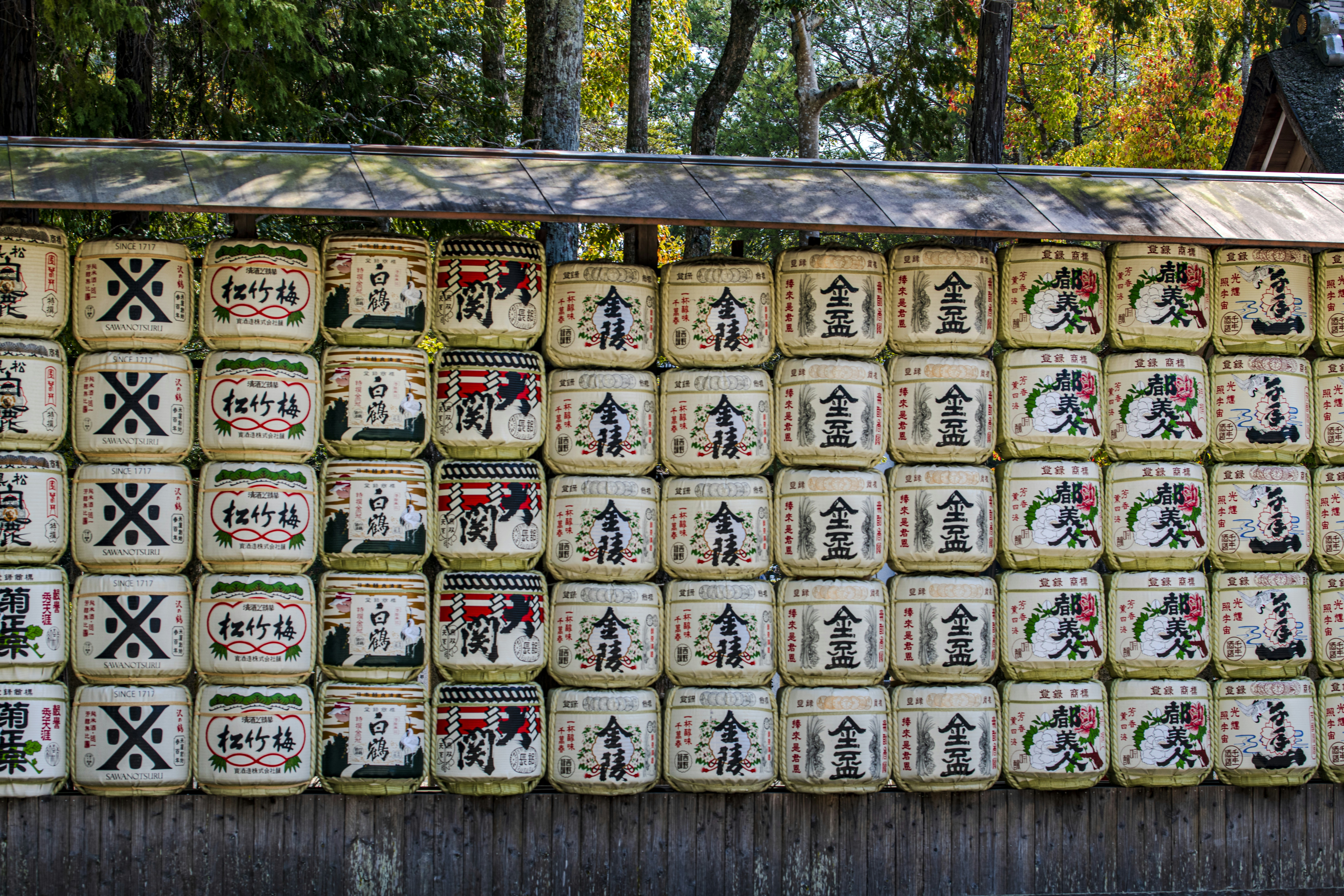 A vibrant display of sake barrels adorned with intricate designs and characters, showcasing the cultural significance of sake in Japanese traditions.