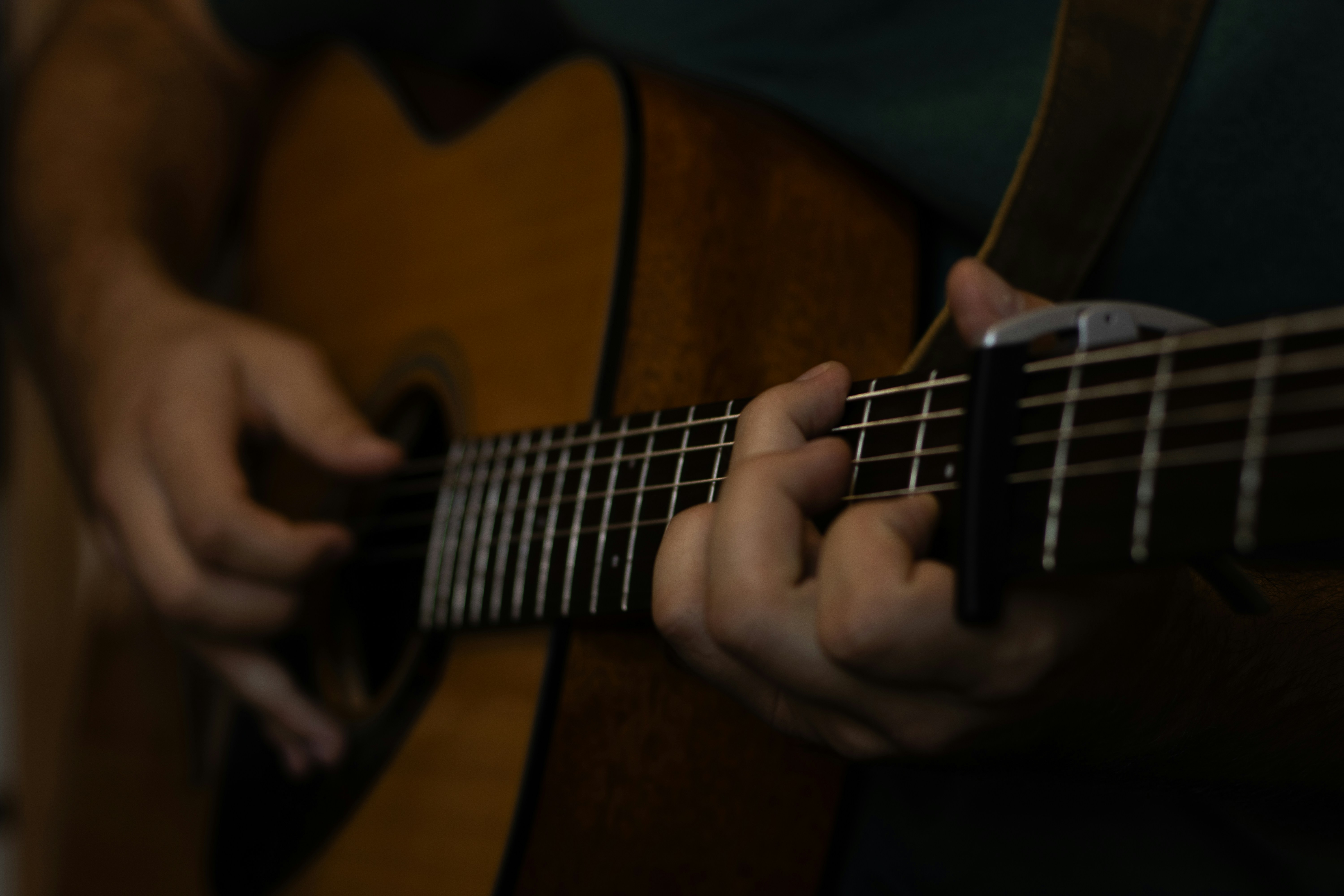 Hands play an acoustic guitar.