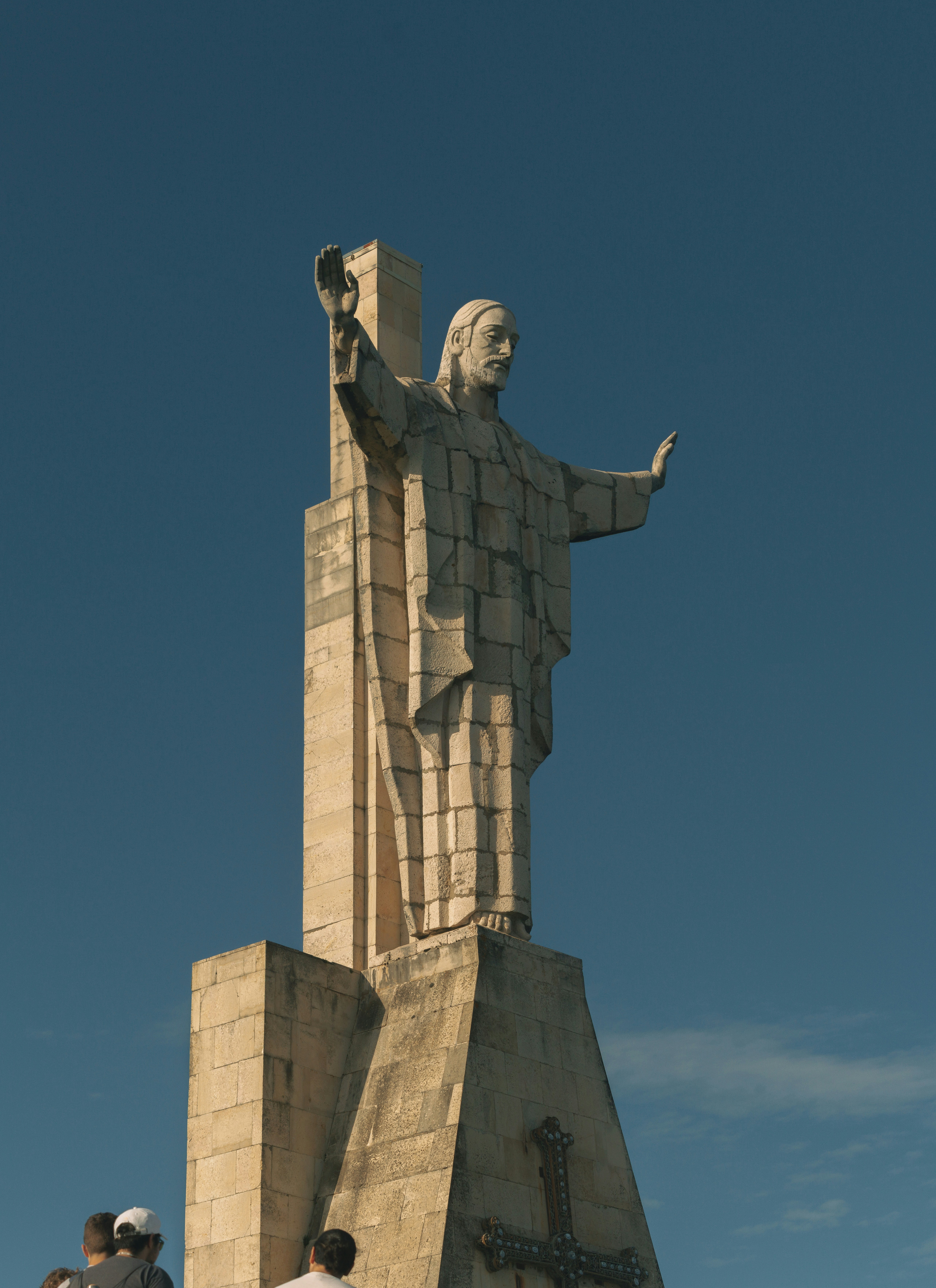A statue of jesus stands tall against the sky.