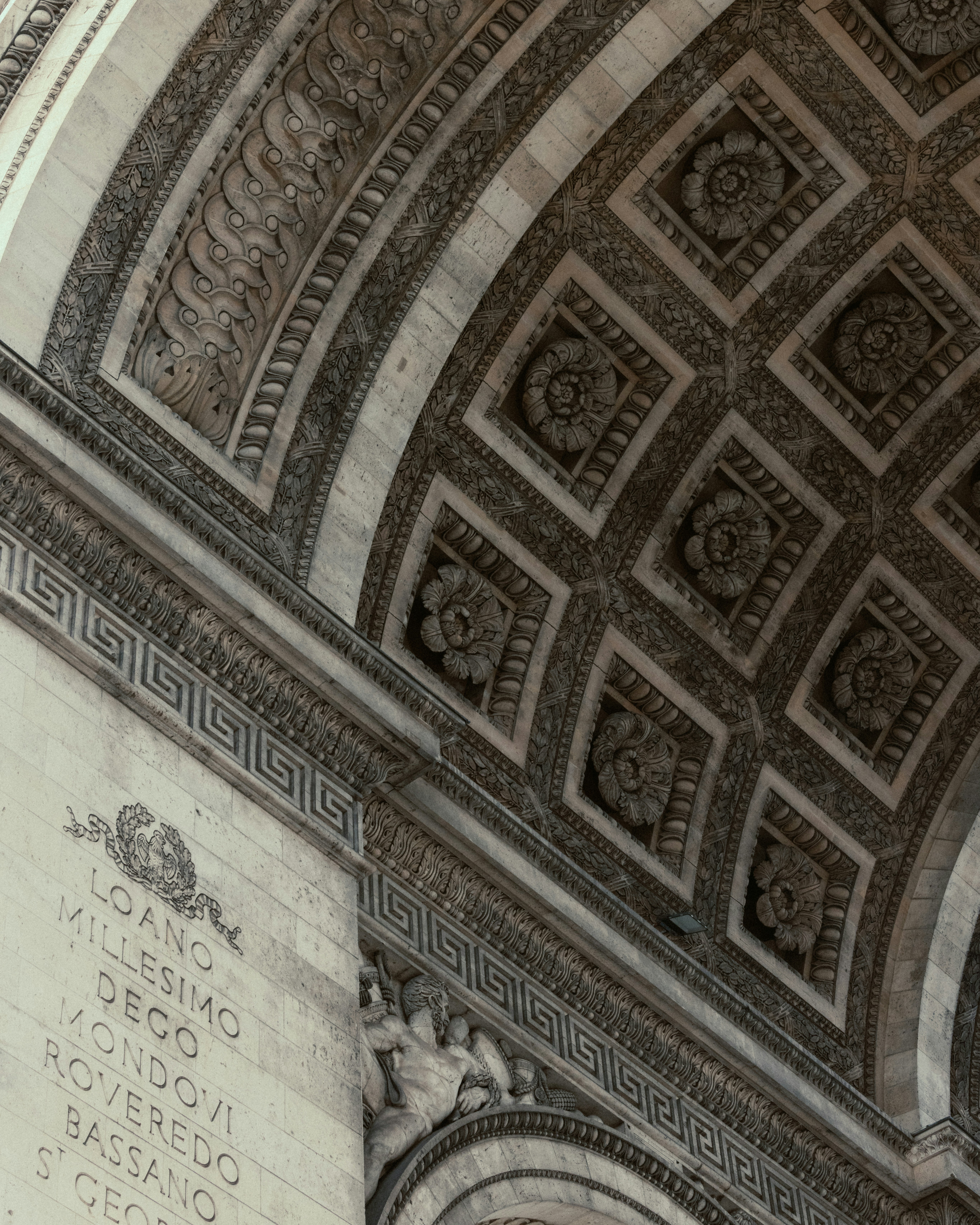 Intricate ceiling details of a historic archway showcasing ornate carvings and classical design elements.