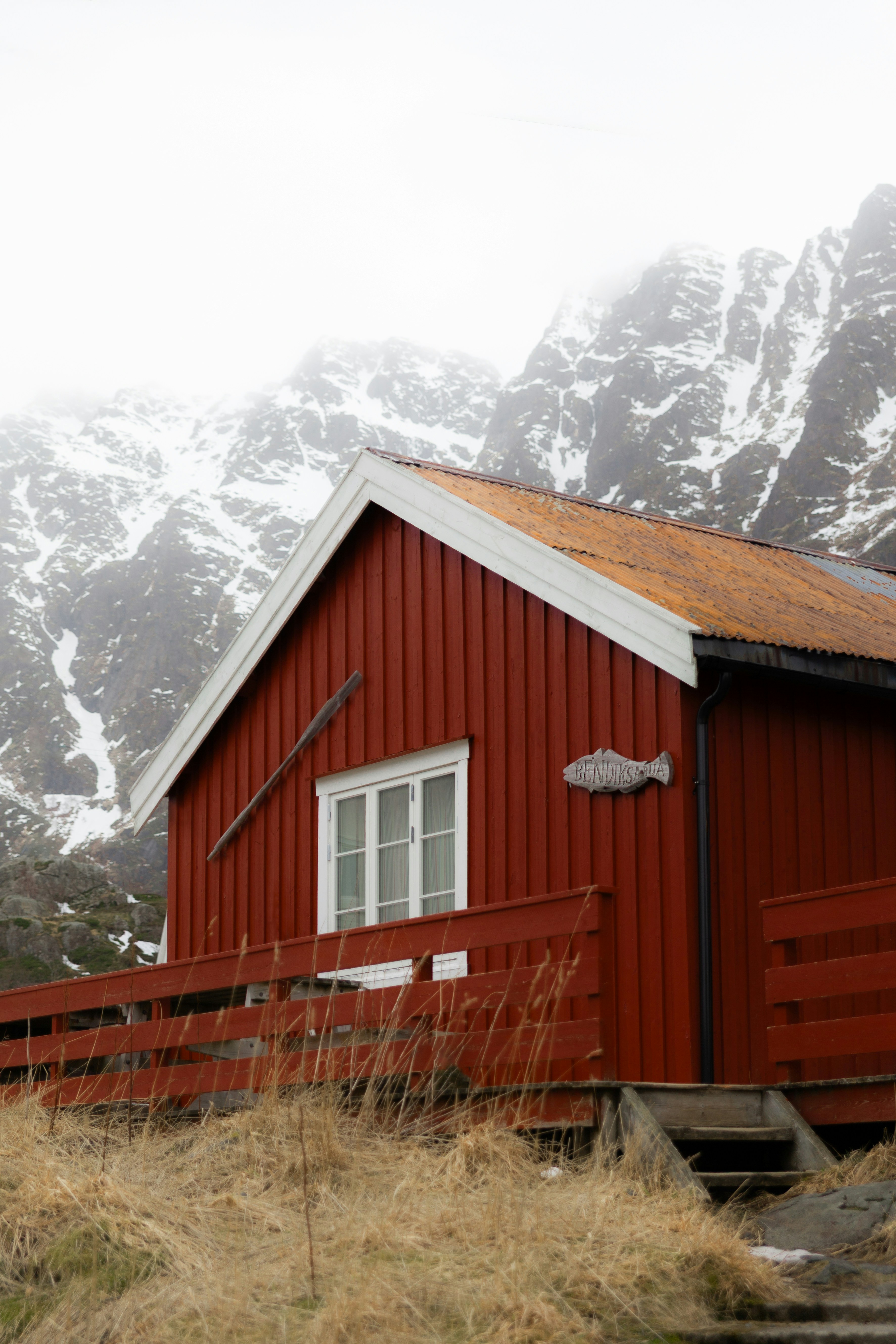 Crimson Cabin Beside Snow-Scaled Peaks