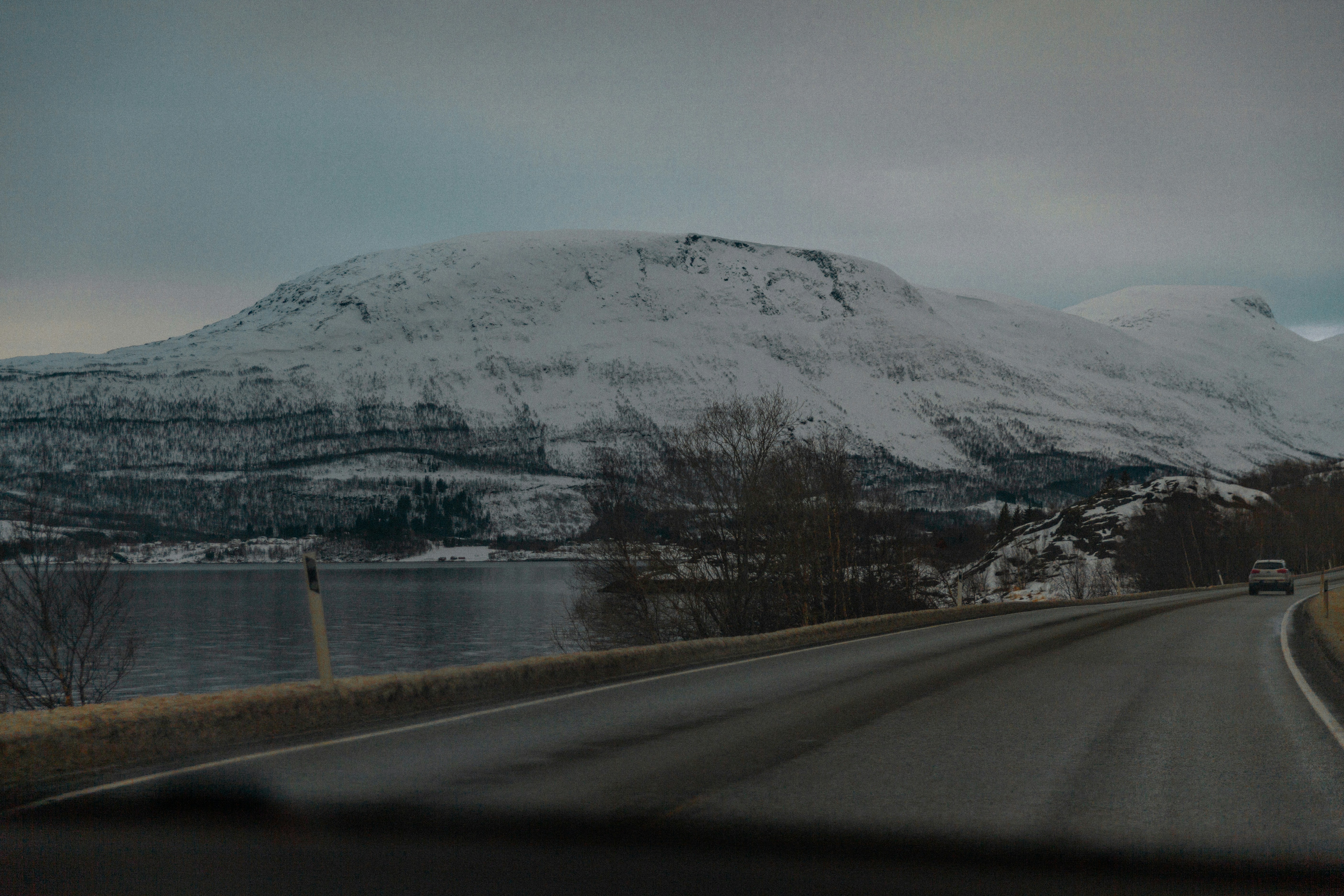 Snowbound Summit Looms Over a Winding Coastal Highway