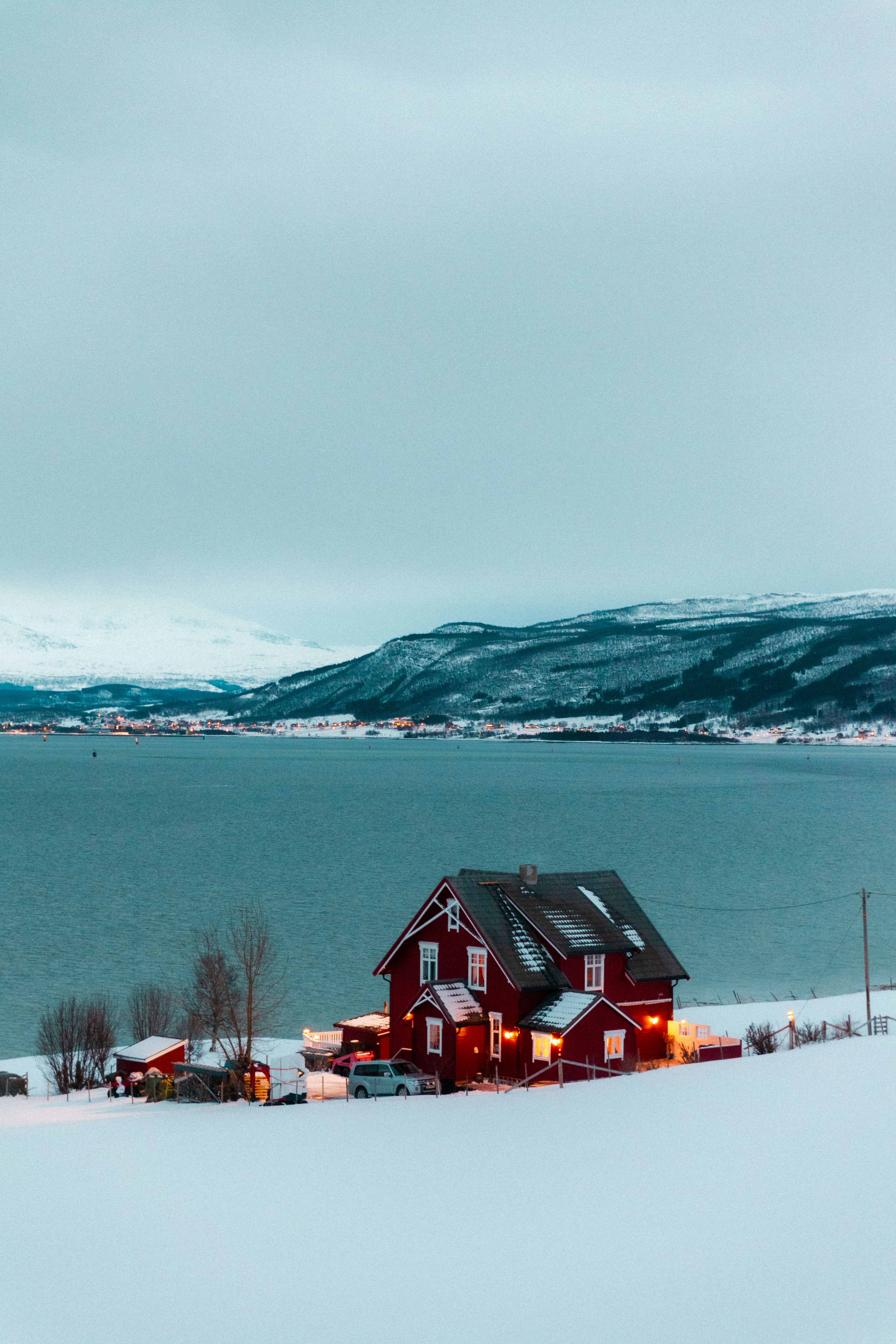 A cozy red house sits by icy waters. photo – Free Travel Image on Unsplash
