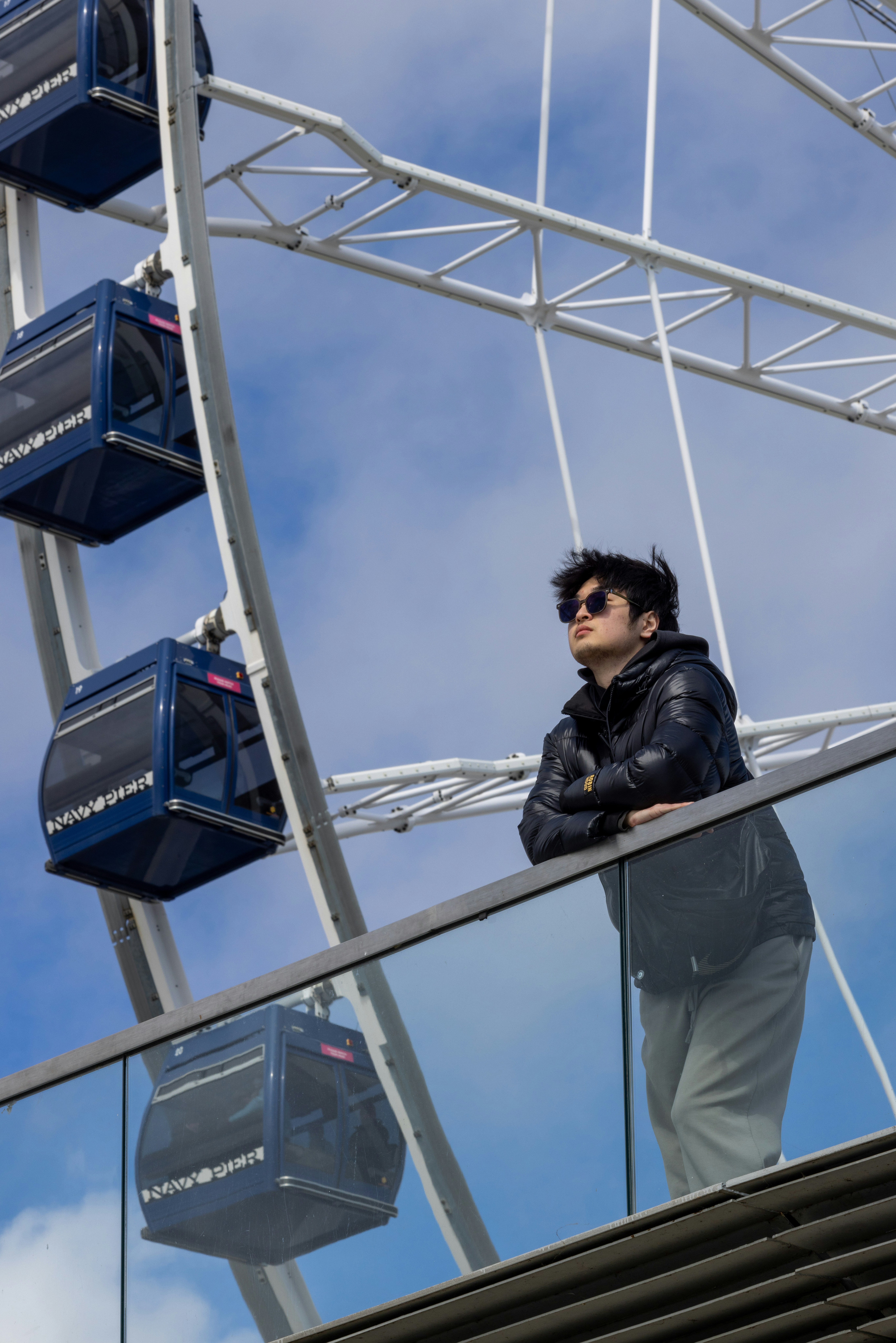 Sunglasses and Steel: a contemplative moment above the Ferris wheel