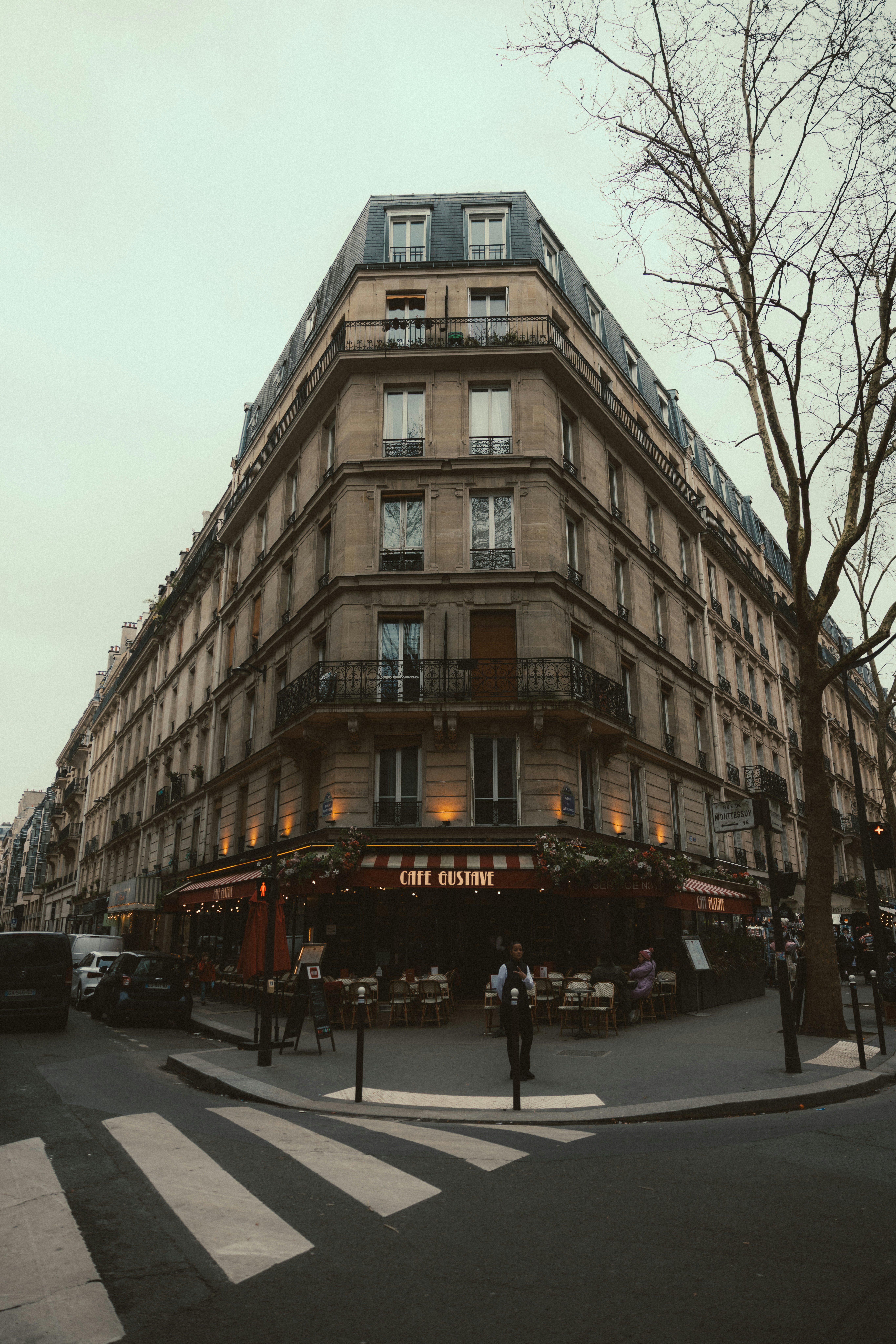 Parisian building with a cafe on a street corner.