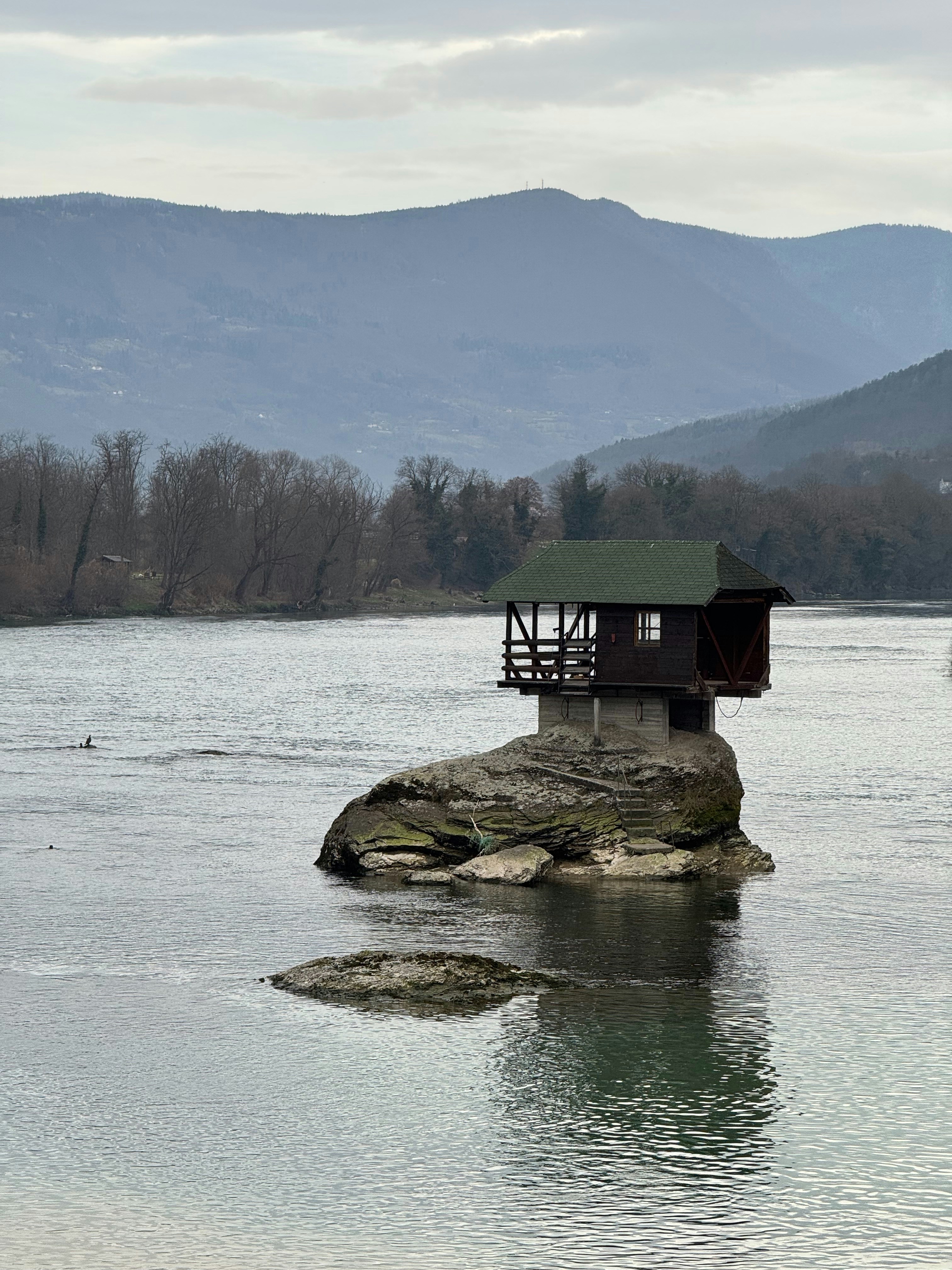 Rock-Islet Refuge: A Quiet Lake Cabin Beneath Distant Blue Ridges
