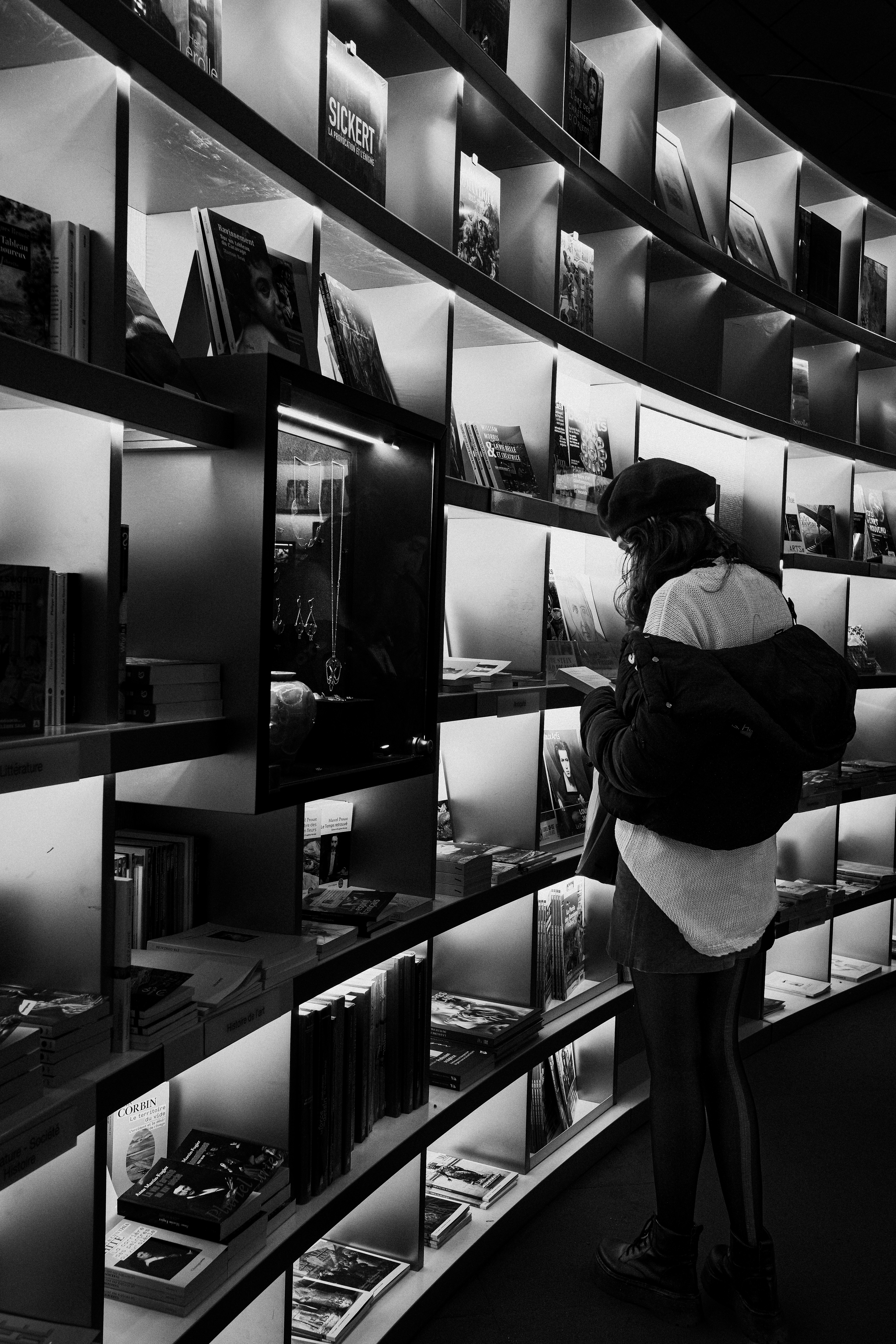 A woman reads books in a well-lit library. photo – Free Woman Image on ...