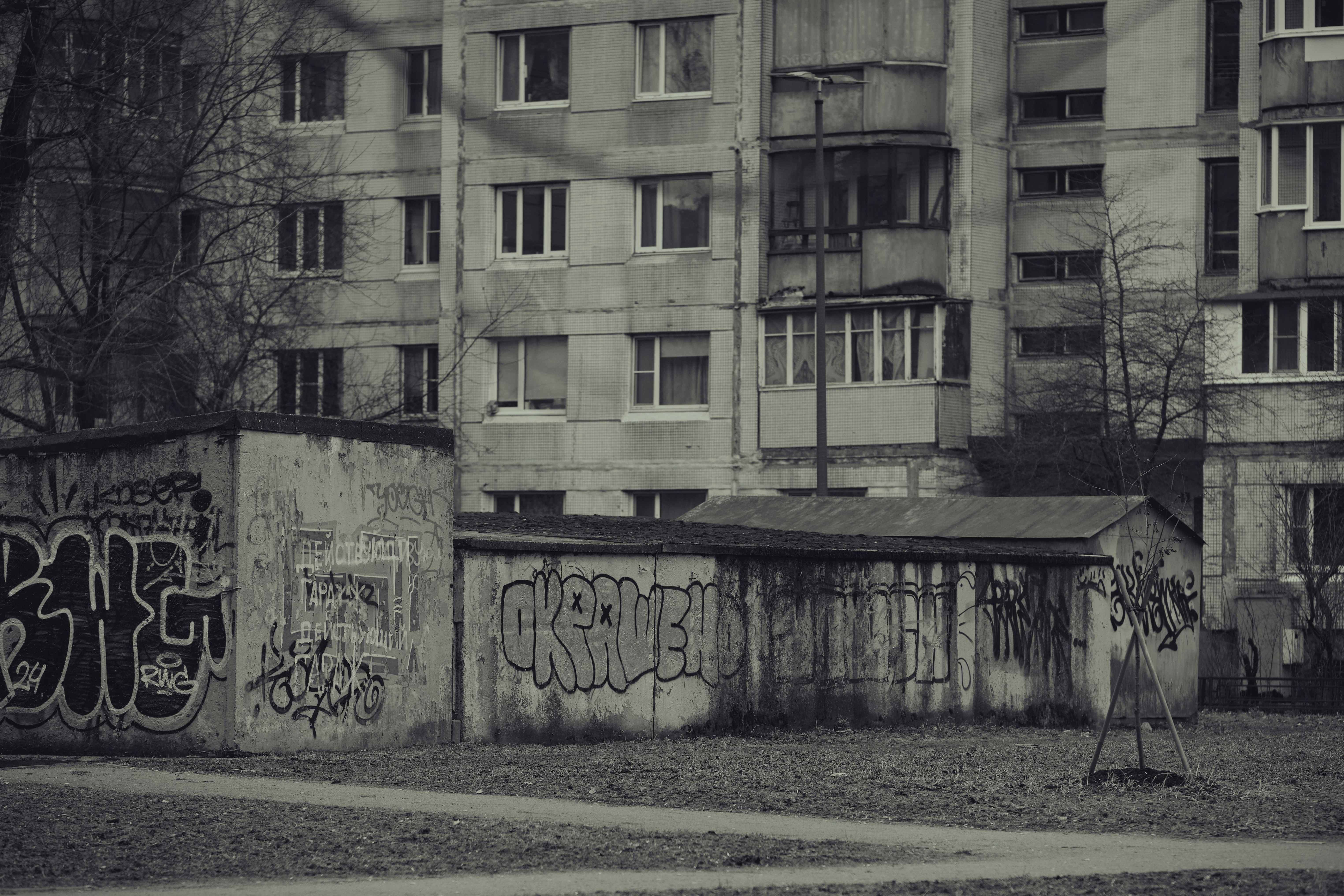 A rundown building with graffiti in black and white.
