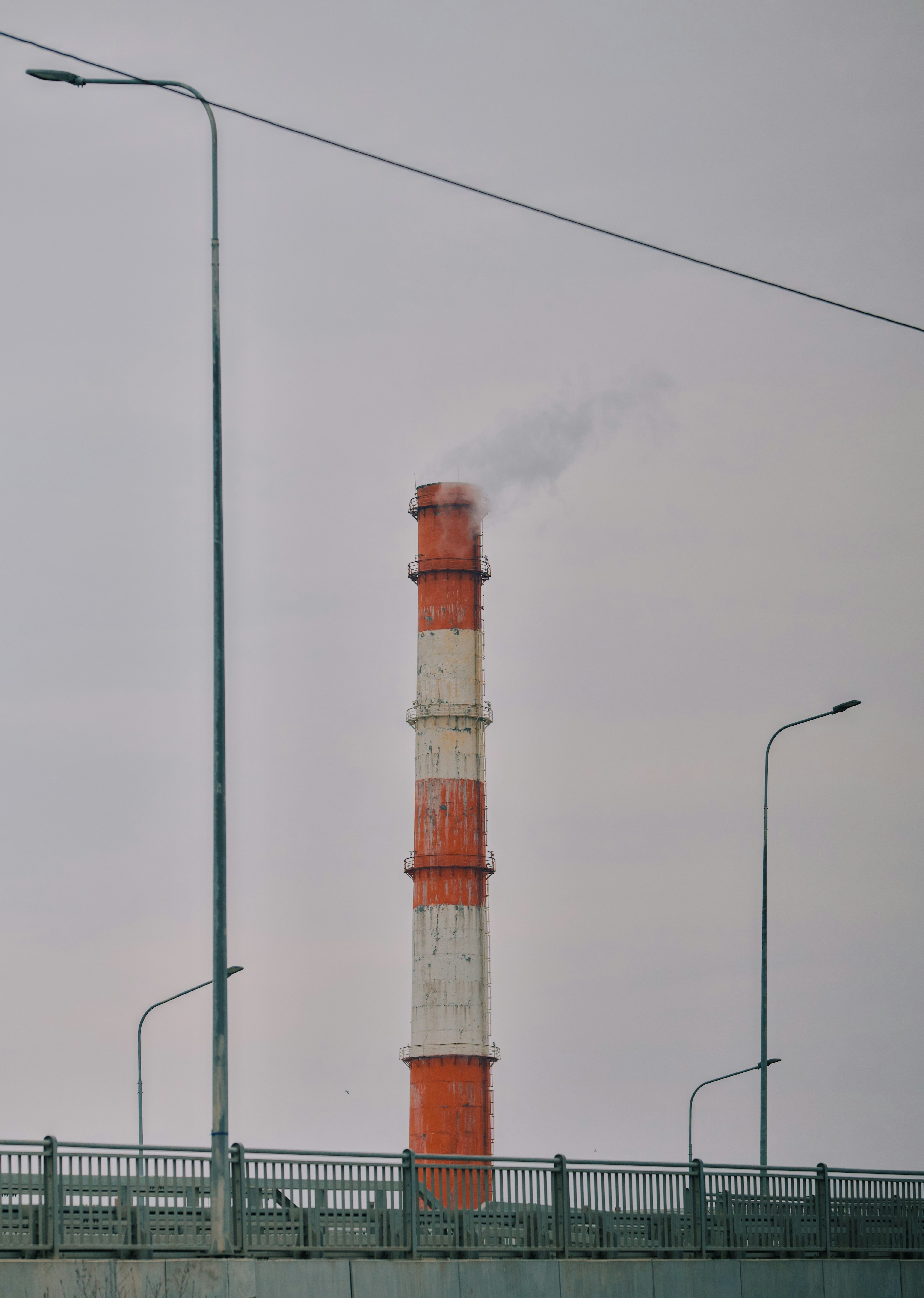 Smokestack releases smoke, next to street lamps. photo – Free Smoke ...