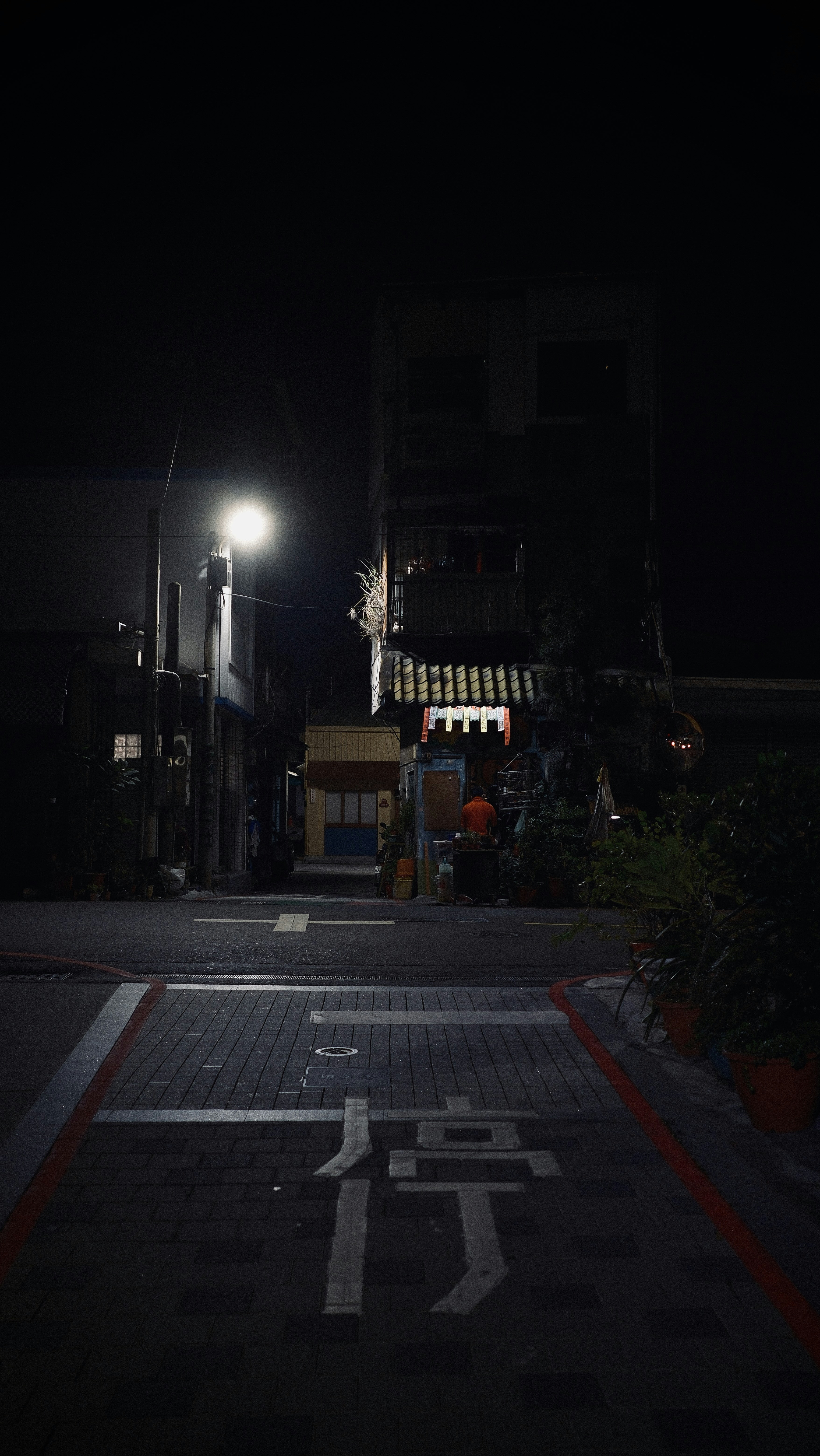 Dark alleyway at night with street sign.