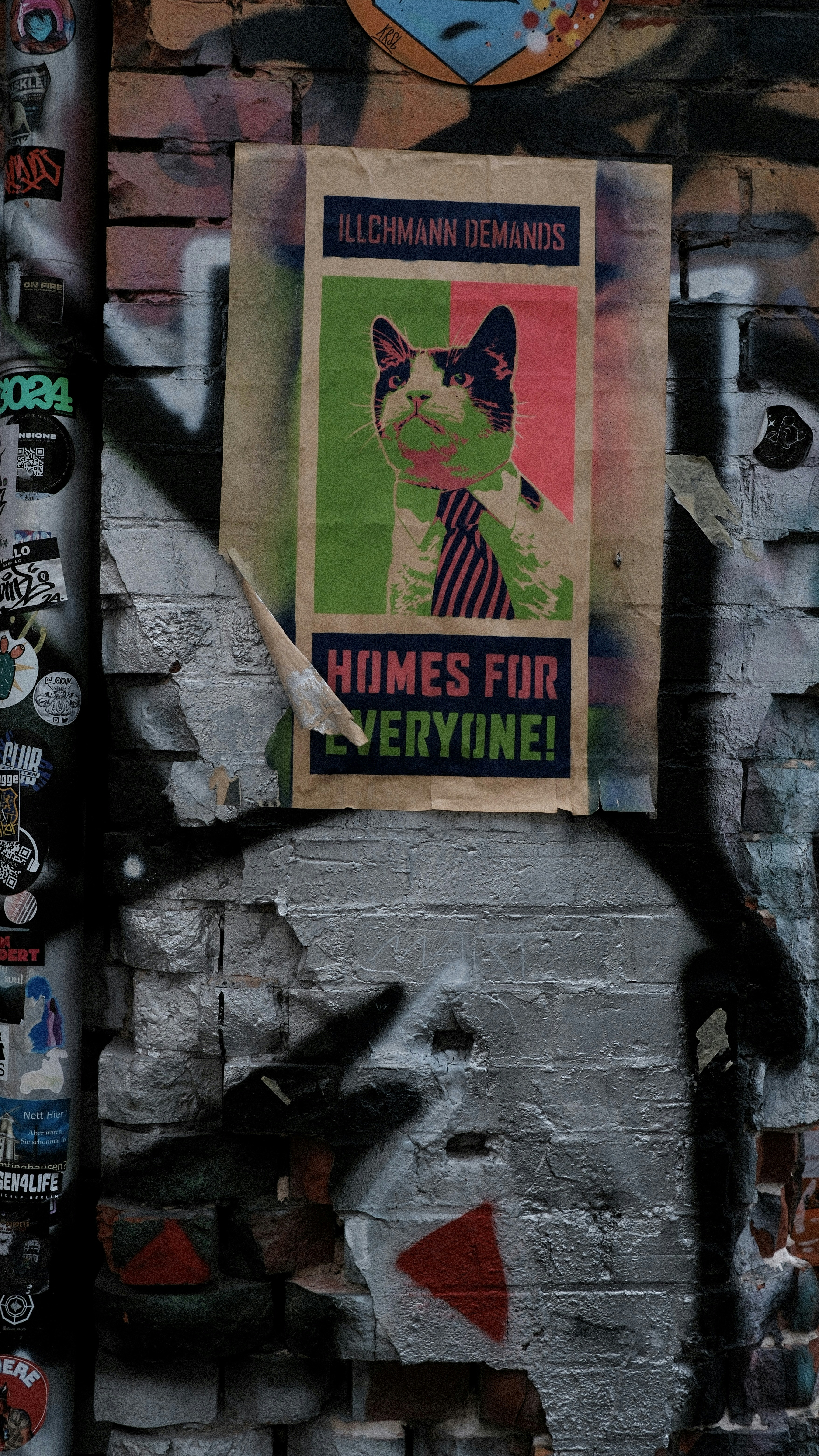 Poster of a Colorful Cat Protest on a Graffiti-Worn Brick Wall