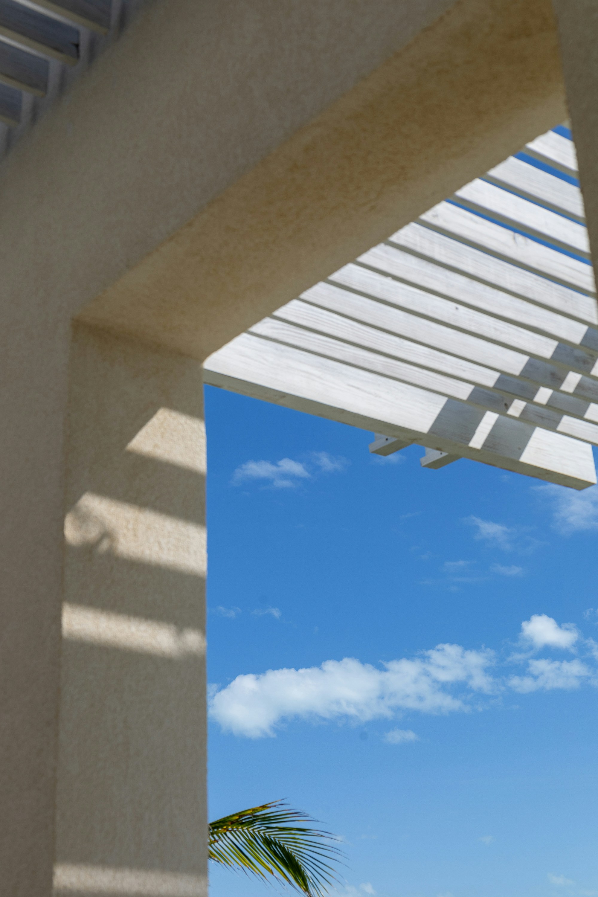 Blue Sky Between Sunlit Beams: A Geometric Archway in Bright Day