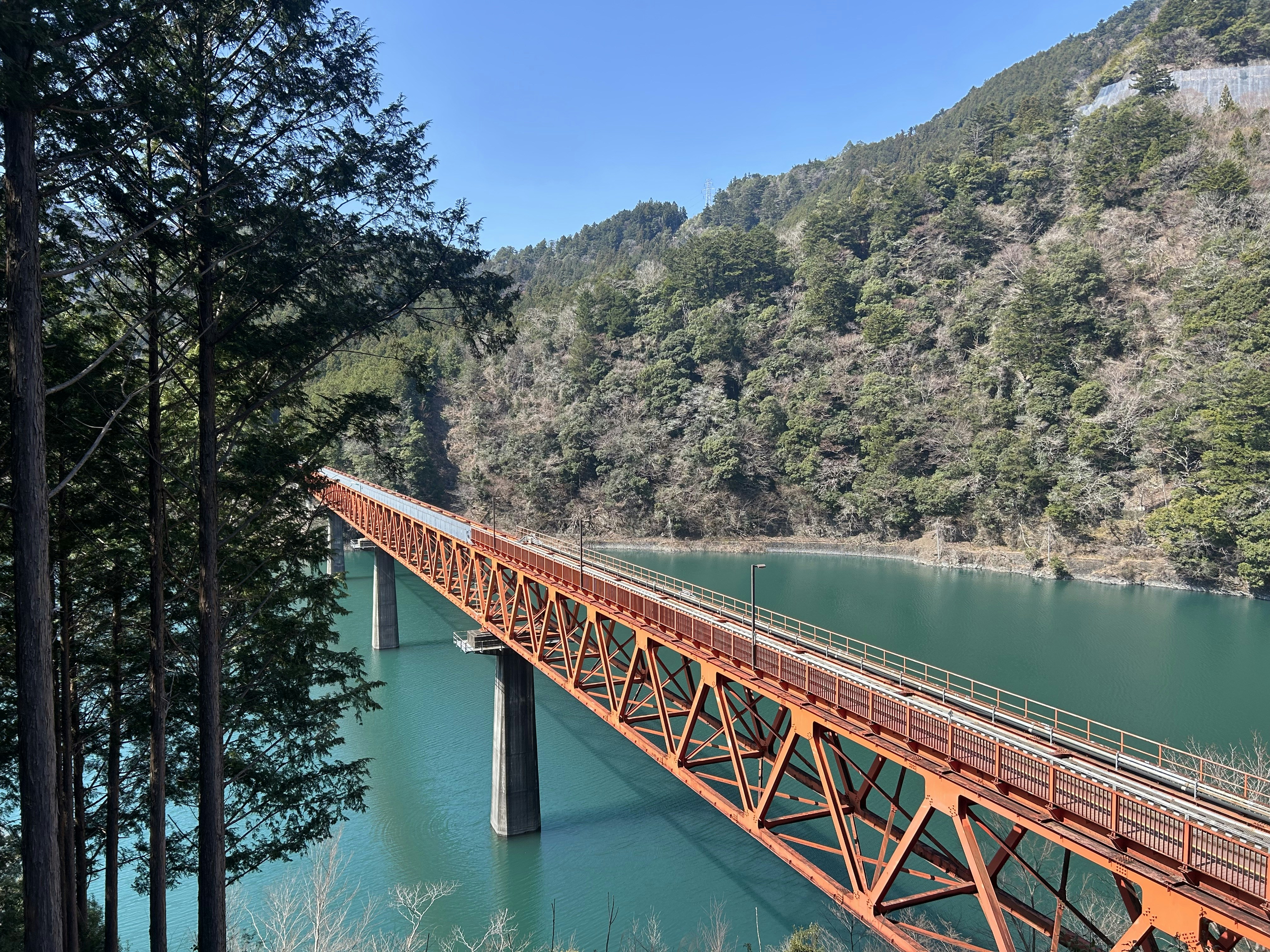 Crimson Truss Crossing Over a Turquoise Mountain Lake