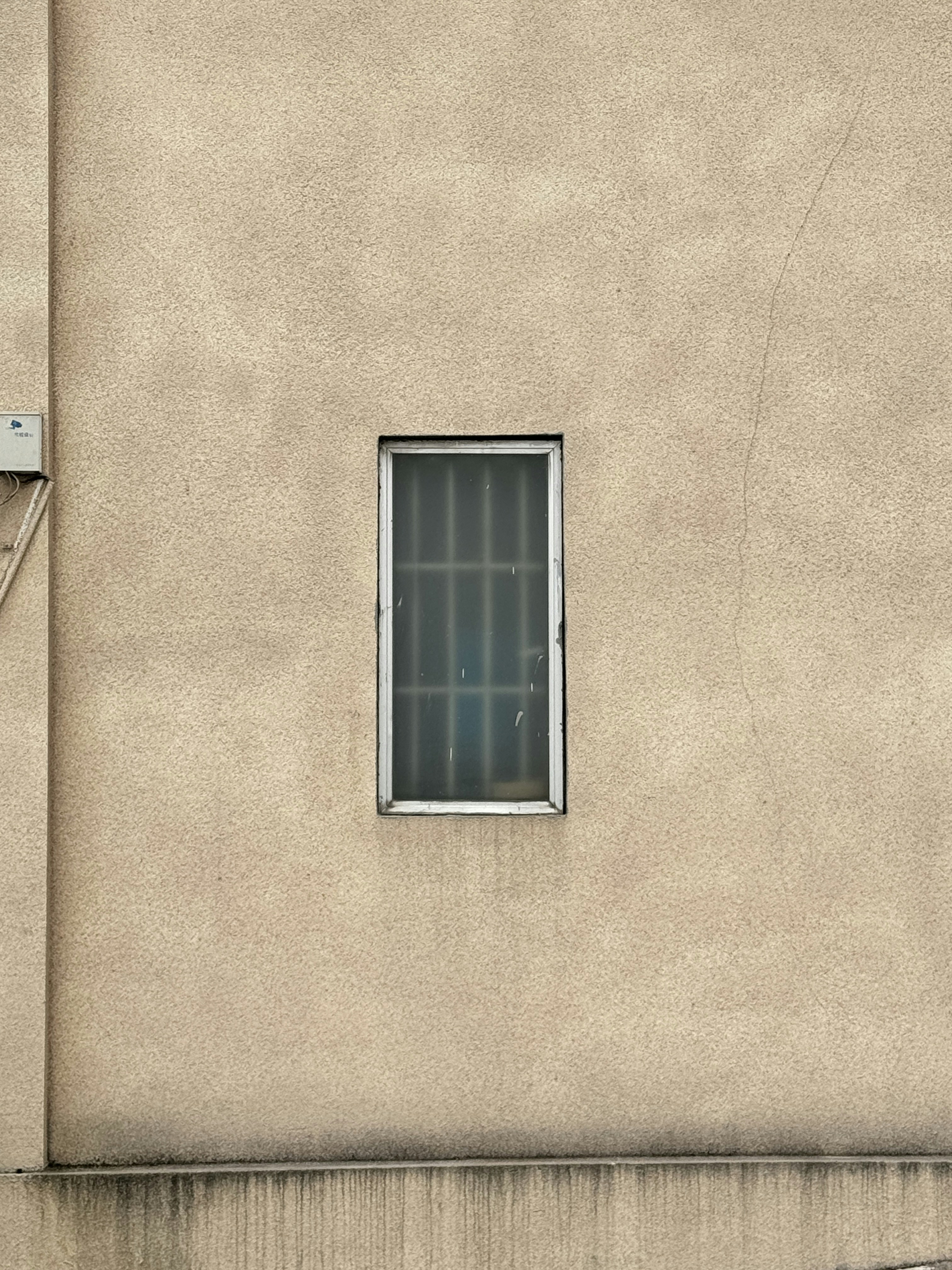 A small, barred window is set in a tan wall. photo – Free Building ...