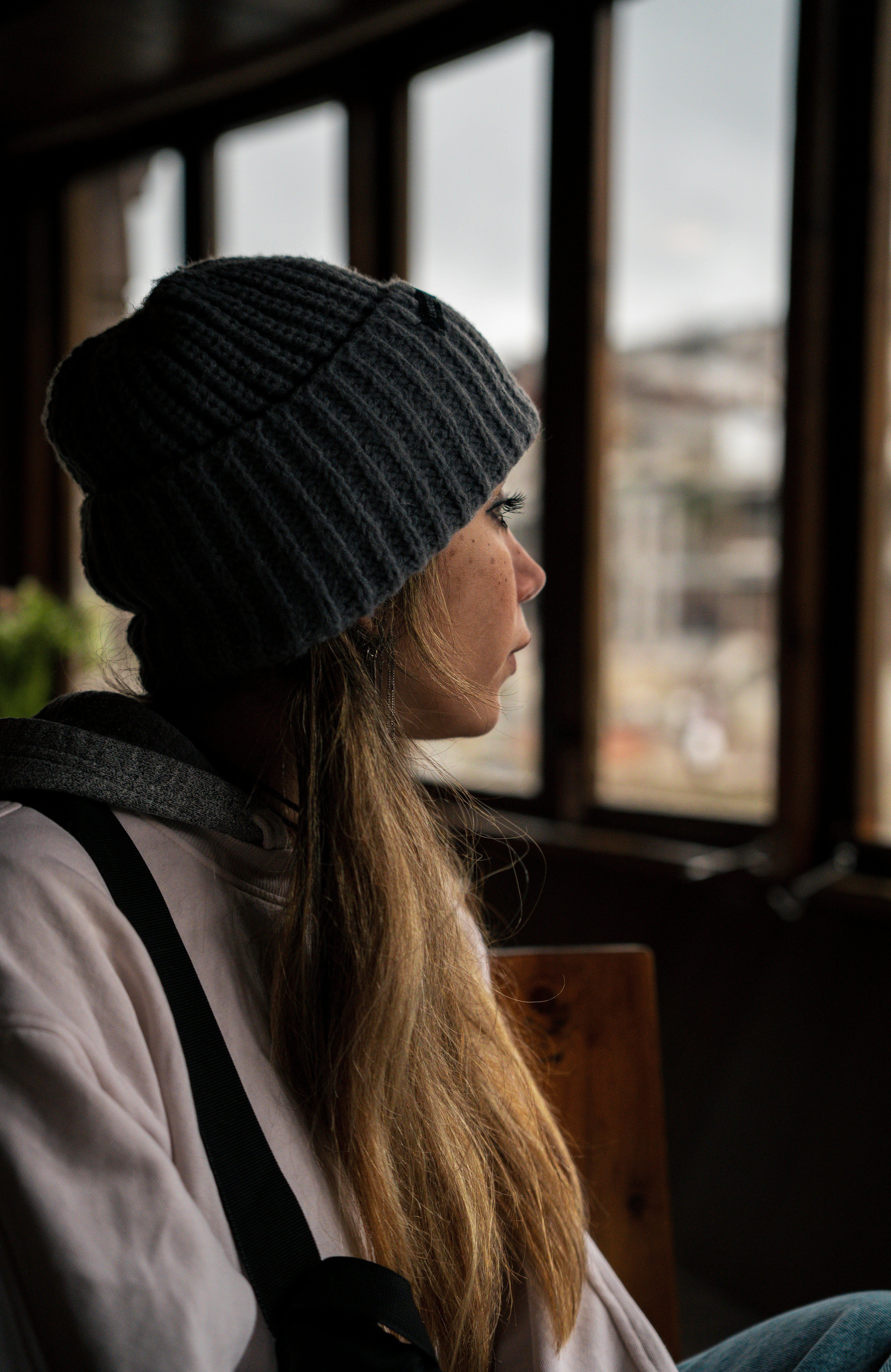 Woman looks out a window, lost in thought