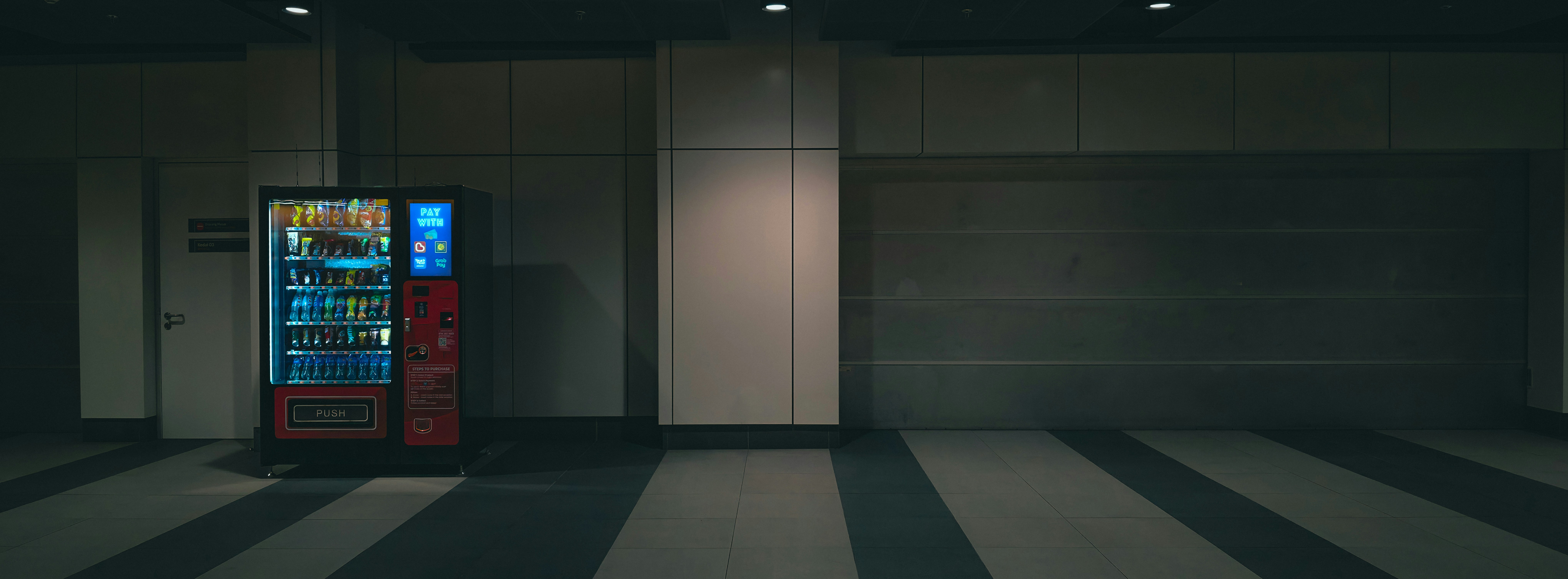 A lonely vending machine sits in a dimly lit space. photo – Free Food ...