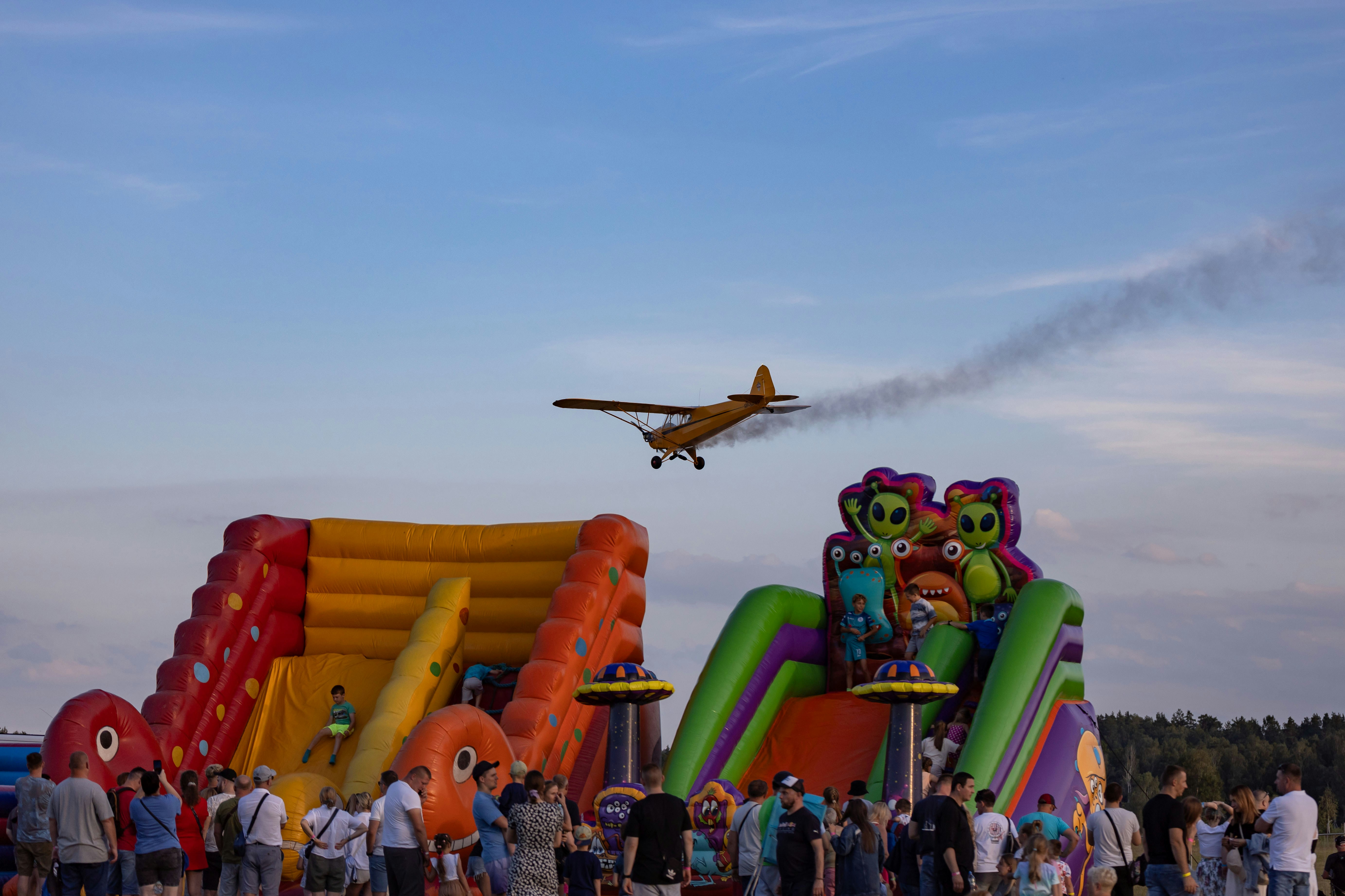 Airshow at the Funfair: A Plane Flyover Above Colorful Jump Castles