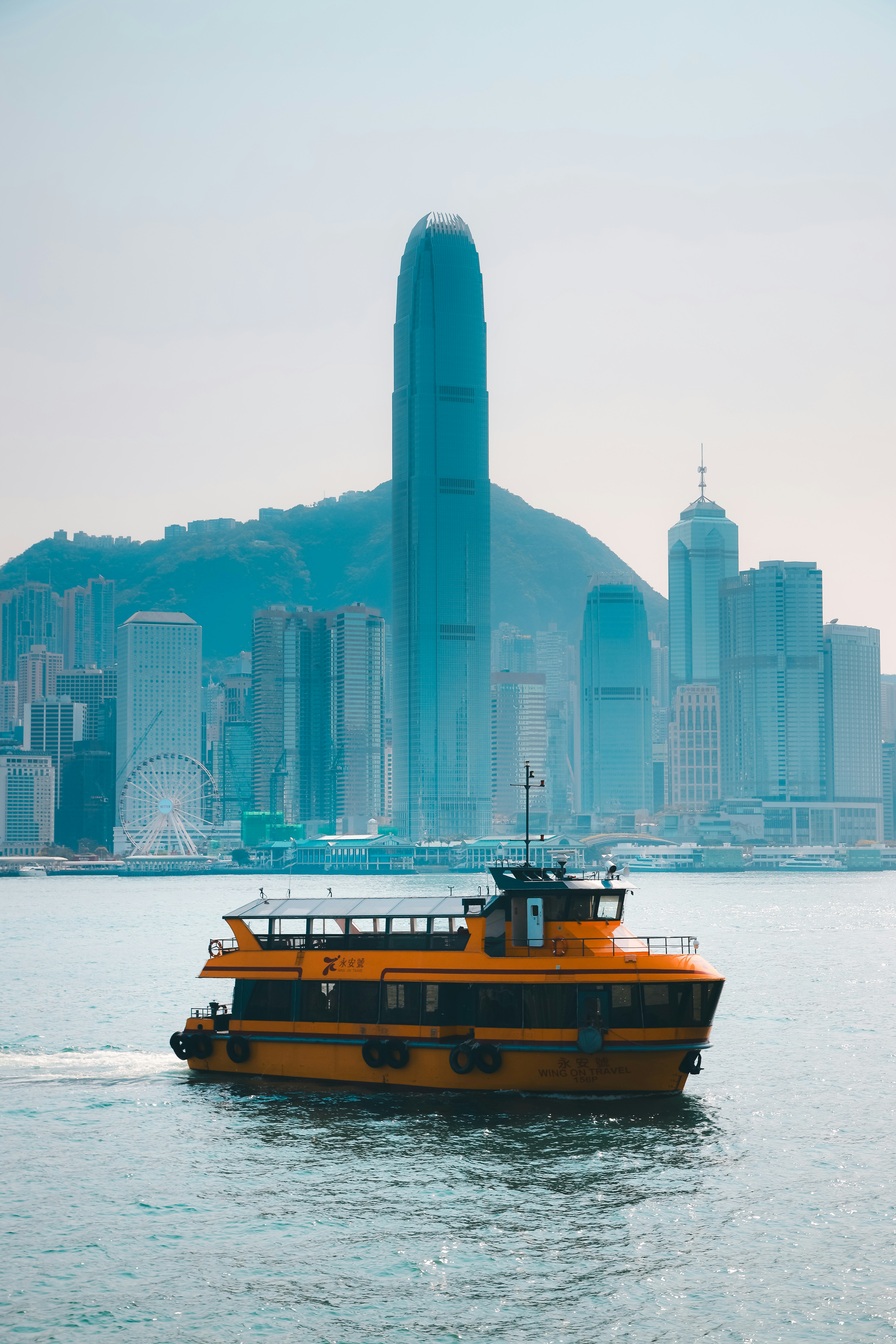 A yellow boat cruises past hong kong's skyline. photo – Free City Image ...