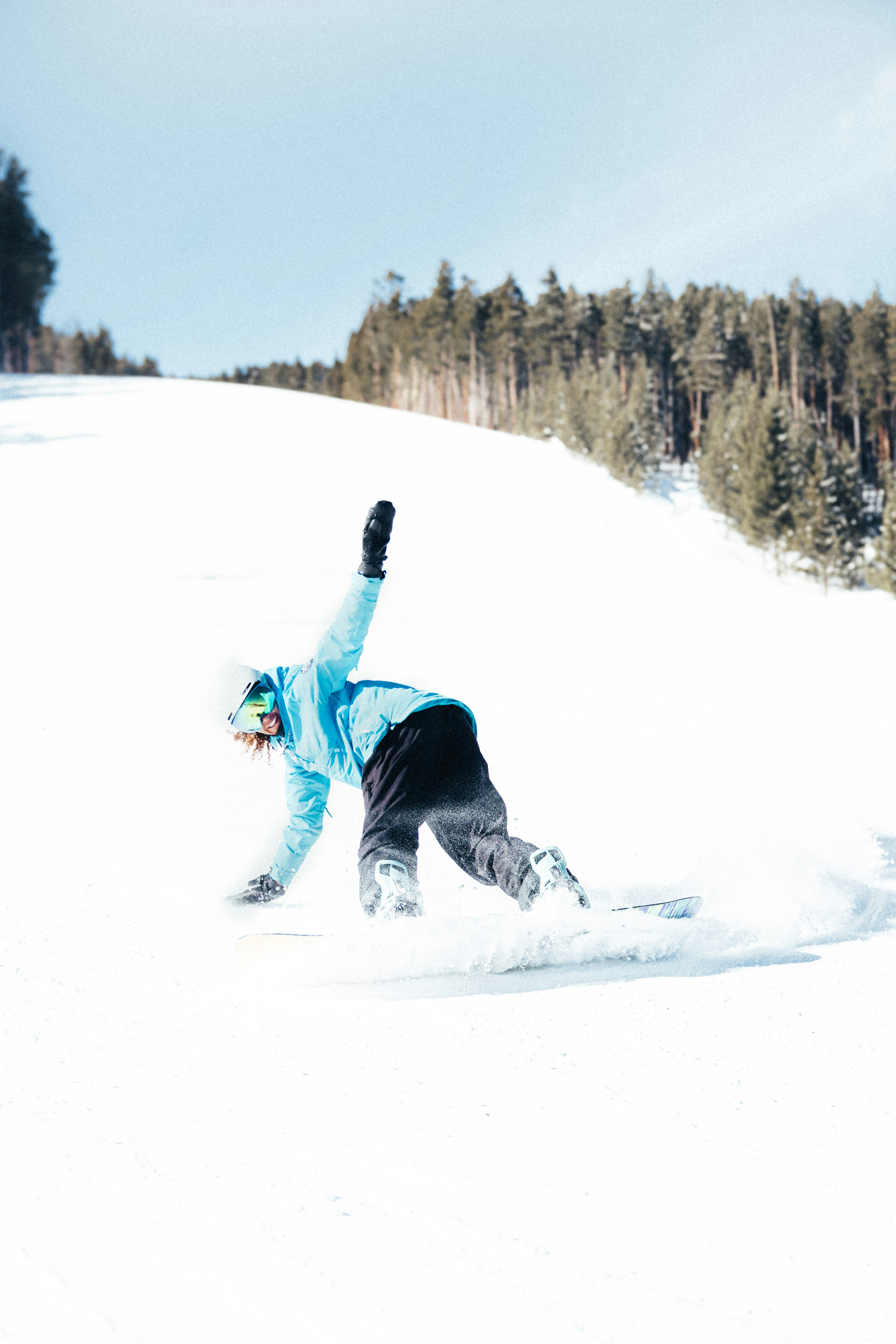 Lgnwvr.com | @Lgnwvr | Snowboarder falls gracefully on a snowy slope.