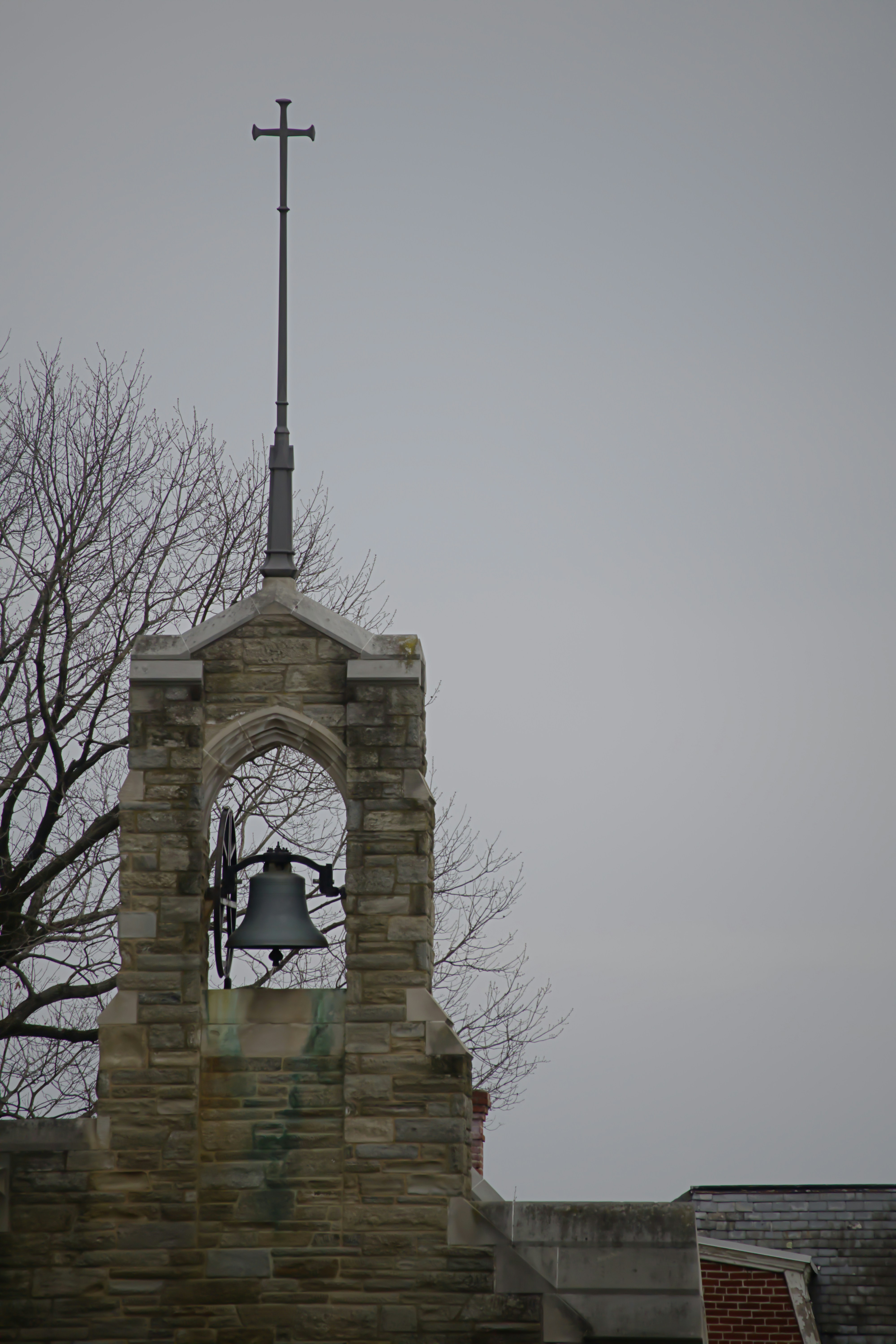 Church bell tower silhouetted against a gray sky.