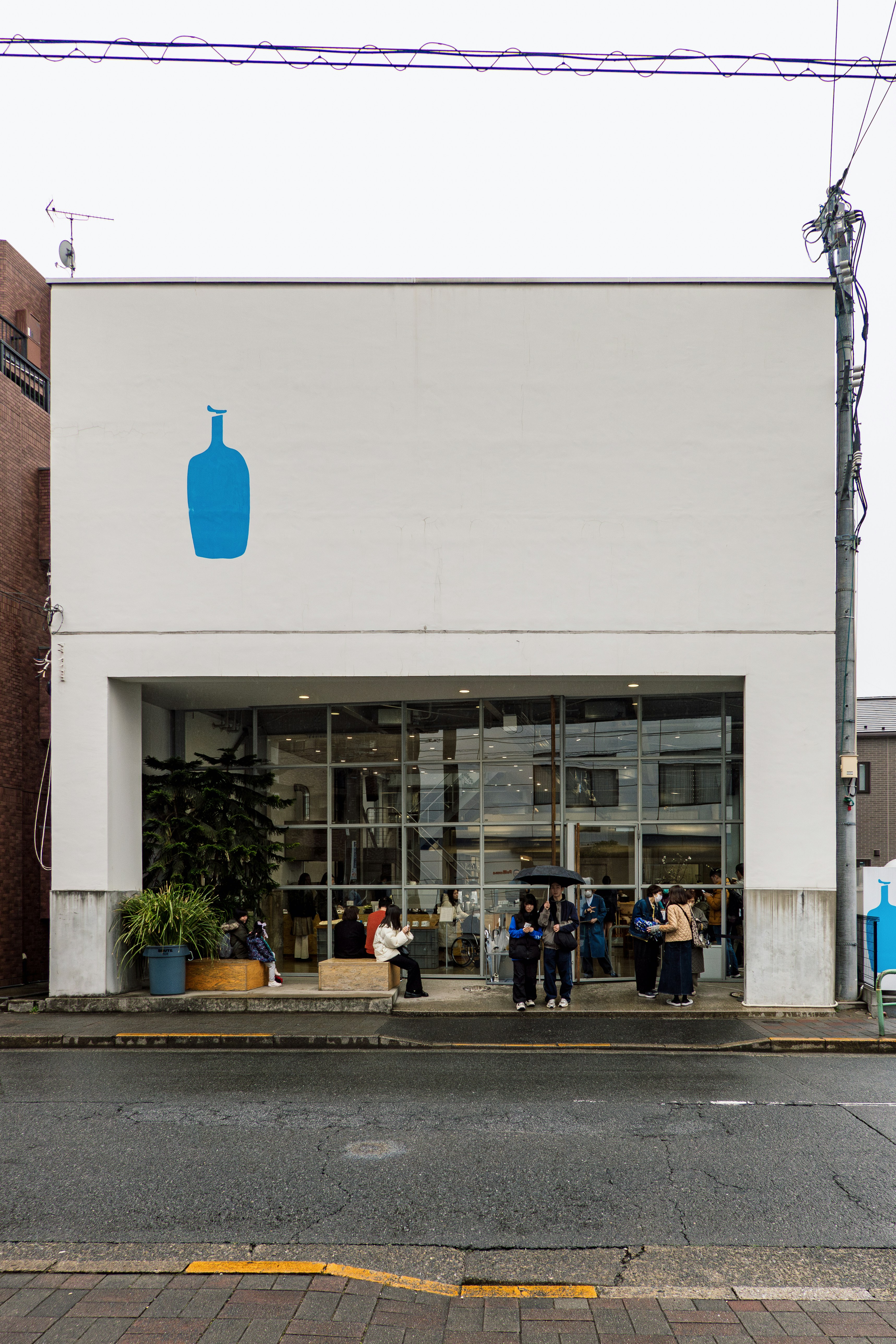 Blue bottle coffee shop with people outside.